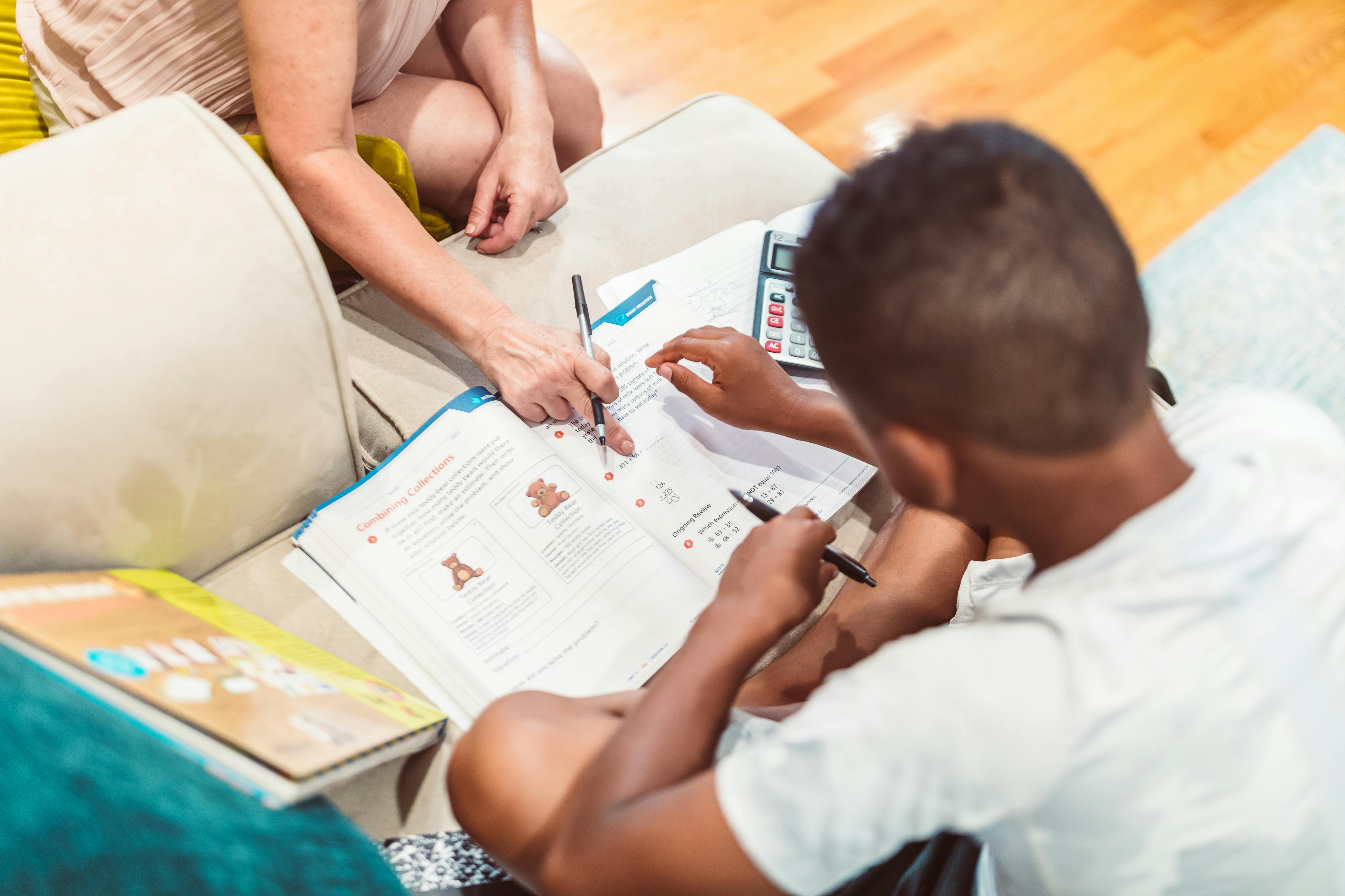 A Person Assisting a Boy in his Homework · Free Stock Photo