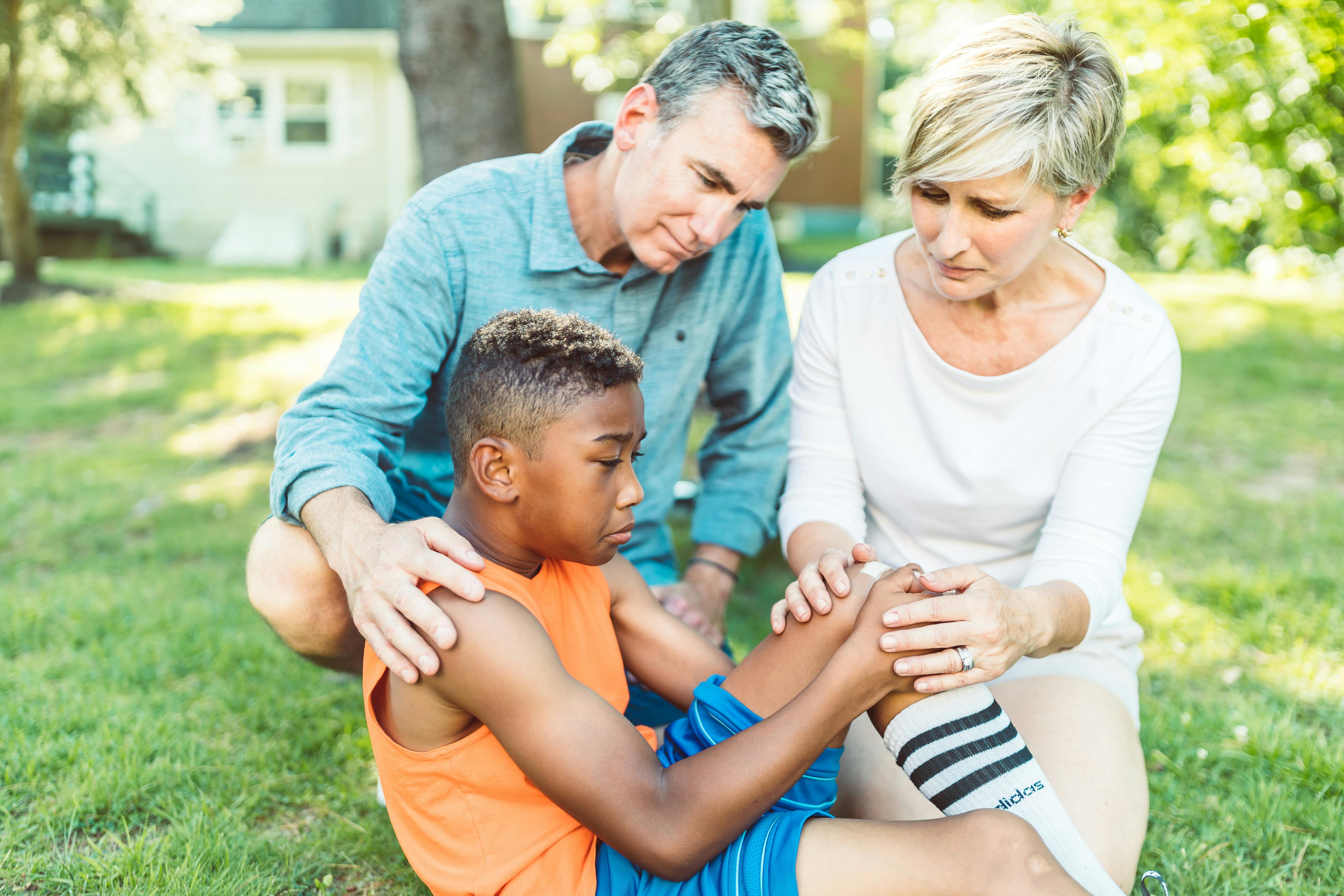 Parents Taking Care of their Son Sitting on the Grass Field · Free ...
