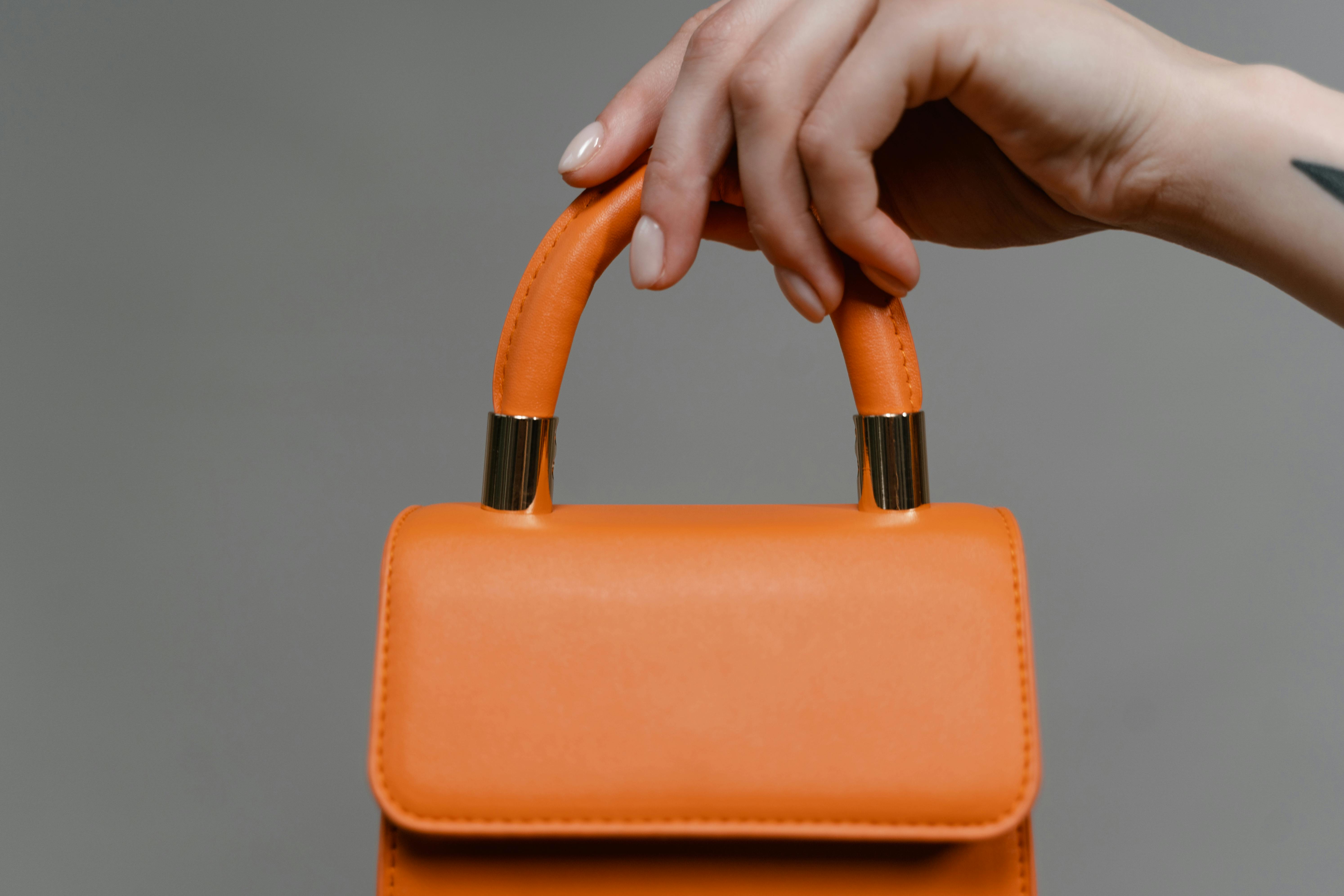 Person Holding Orange Leather Handbag · Free Stock Photo