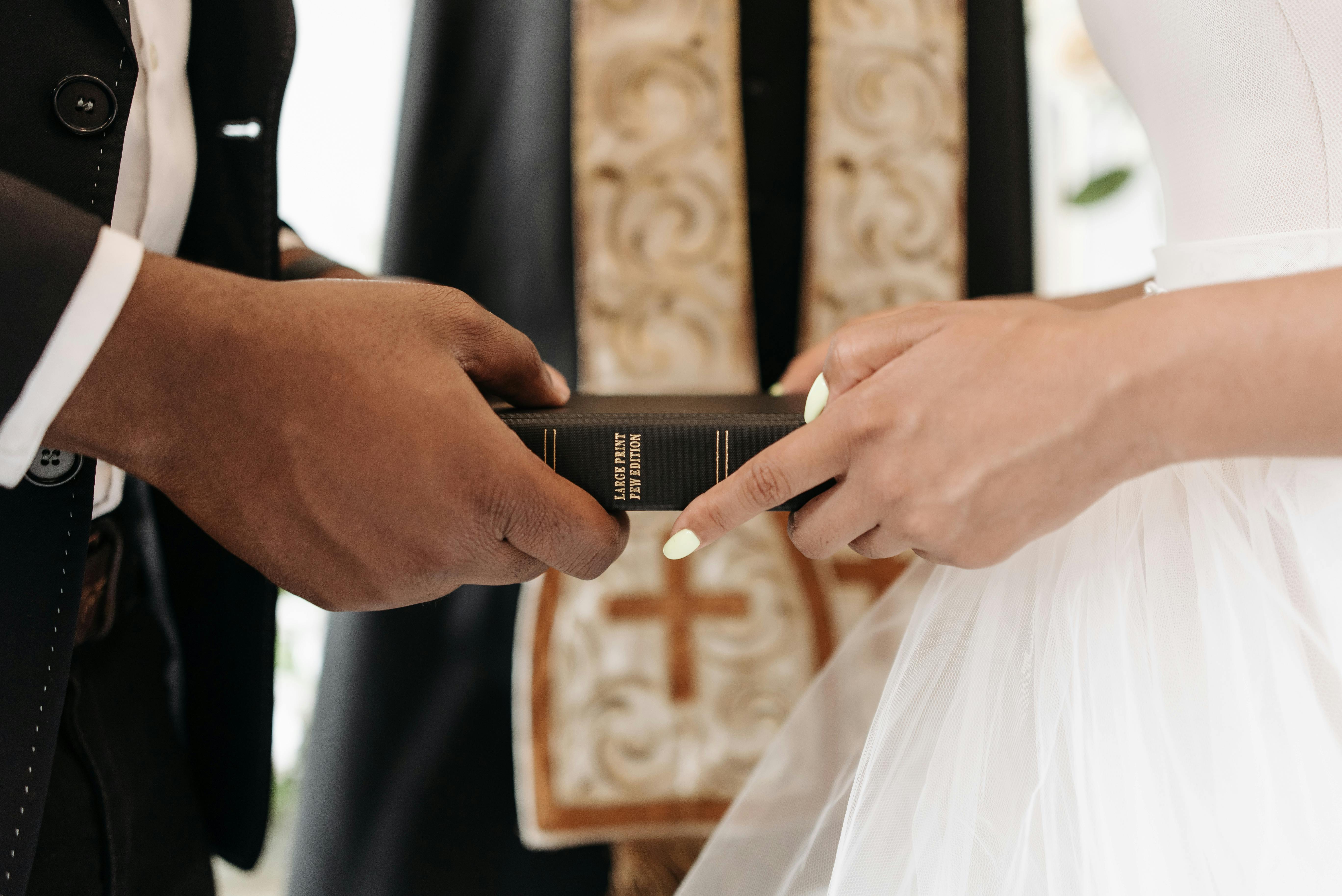 Bride and Groom holding a Bible · Free Stock Photo