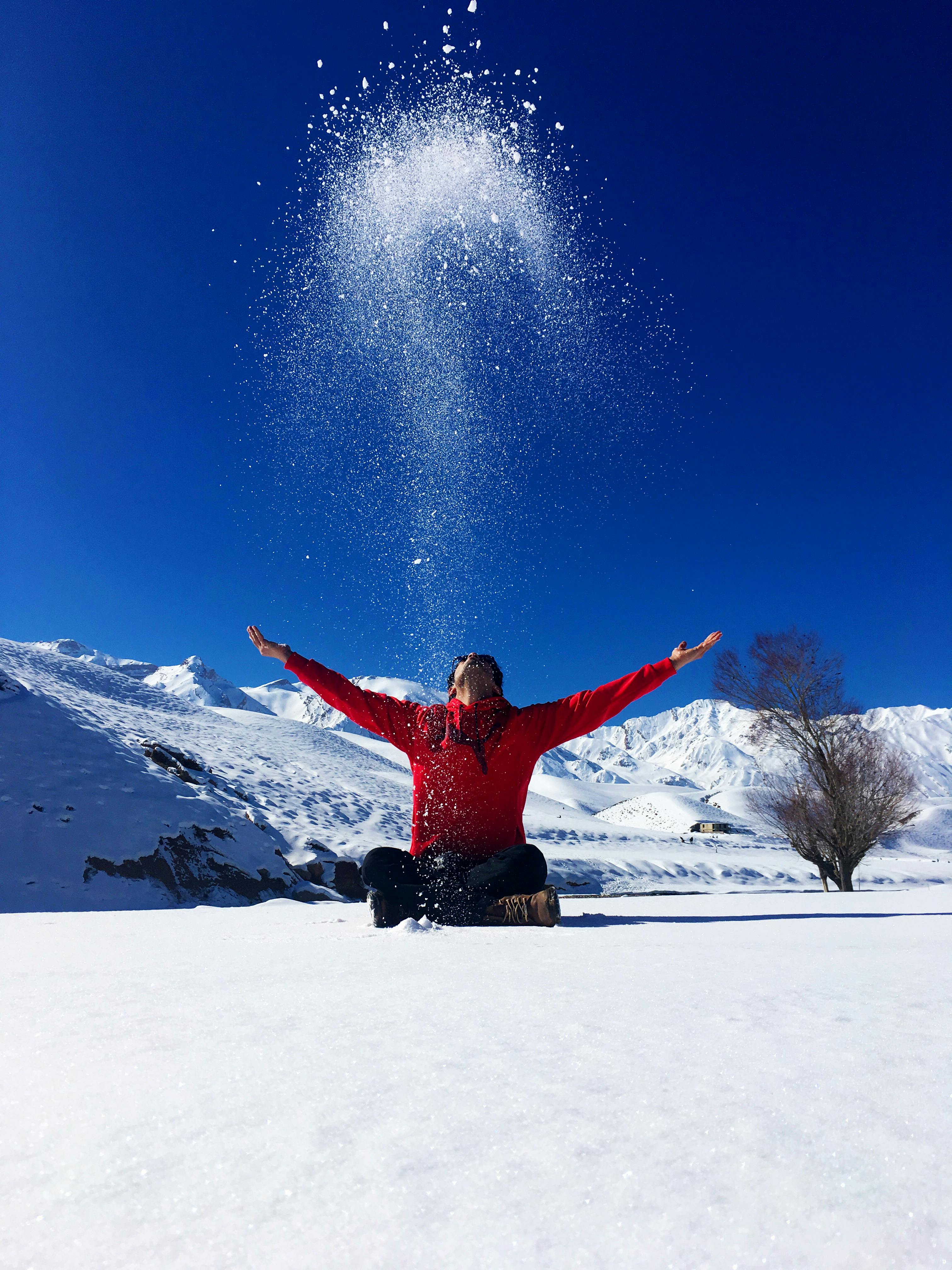 Man Sitting and Throwing Snow in Air · Free Stock Photo