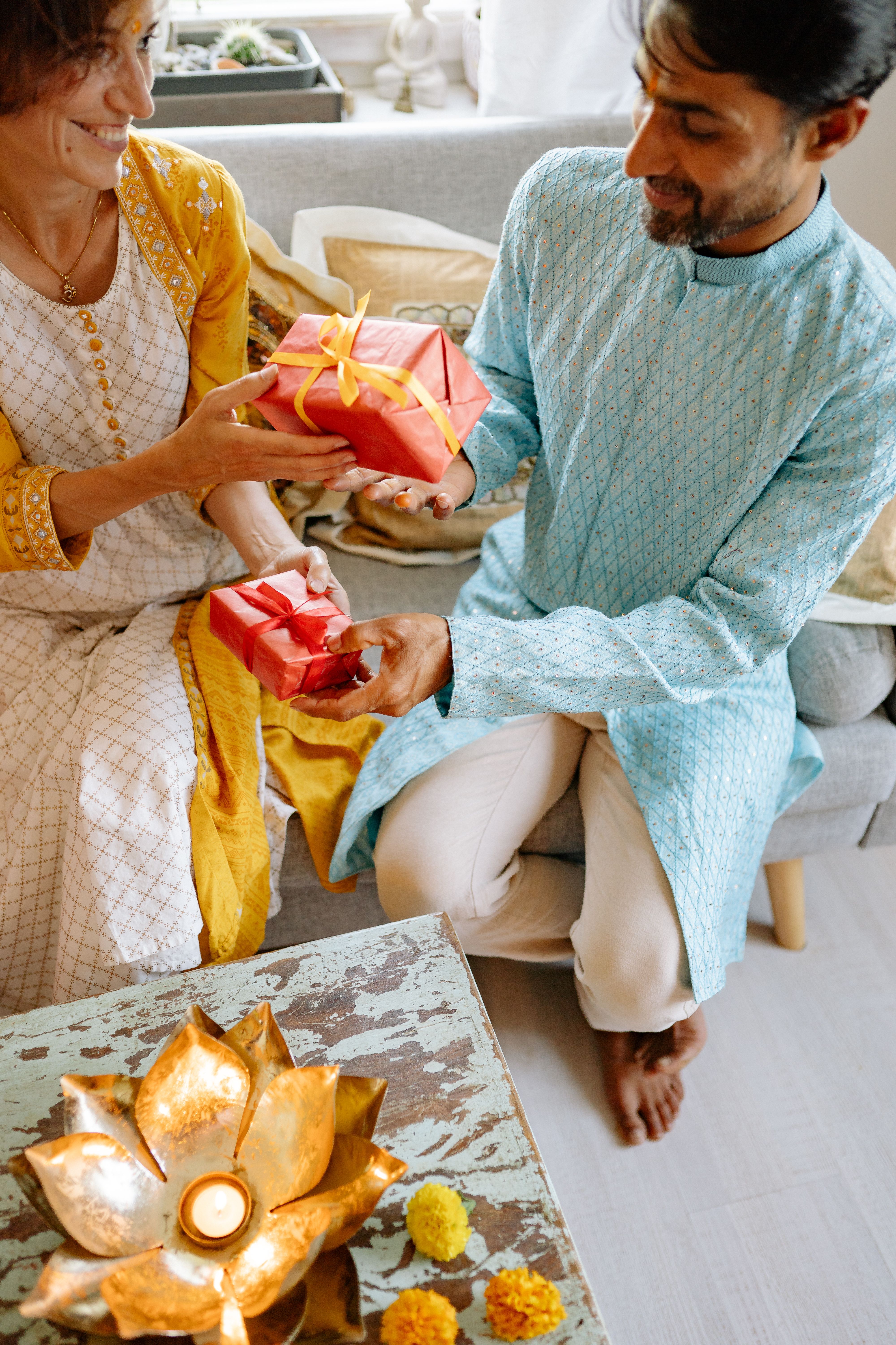 Man and Woman Exchanging Gifts While Sitting on a Sofa · Free Stock Photo