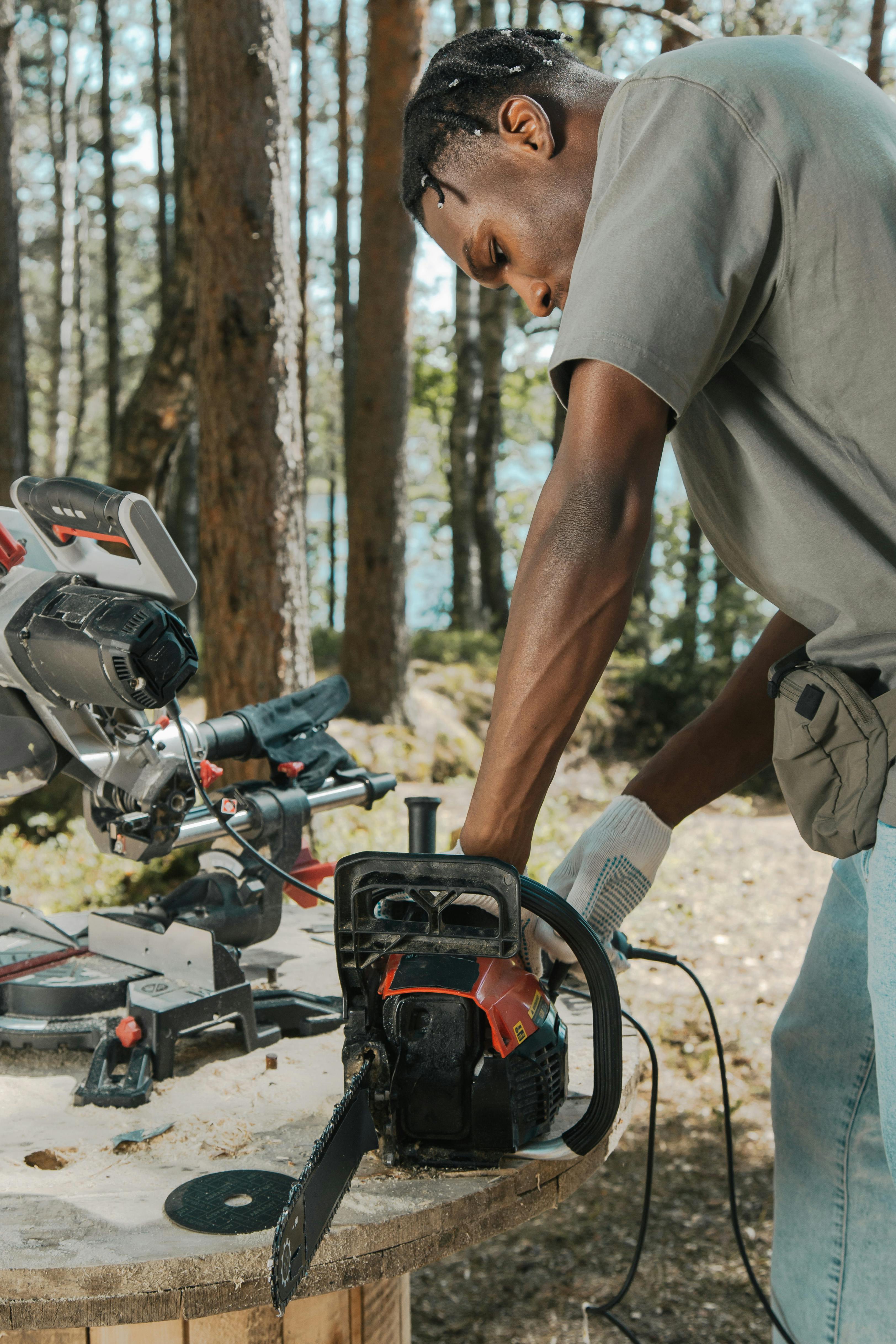 Man Starting a Chain Saw on a Construction Site · Free Stock Photo