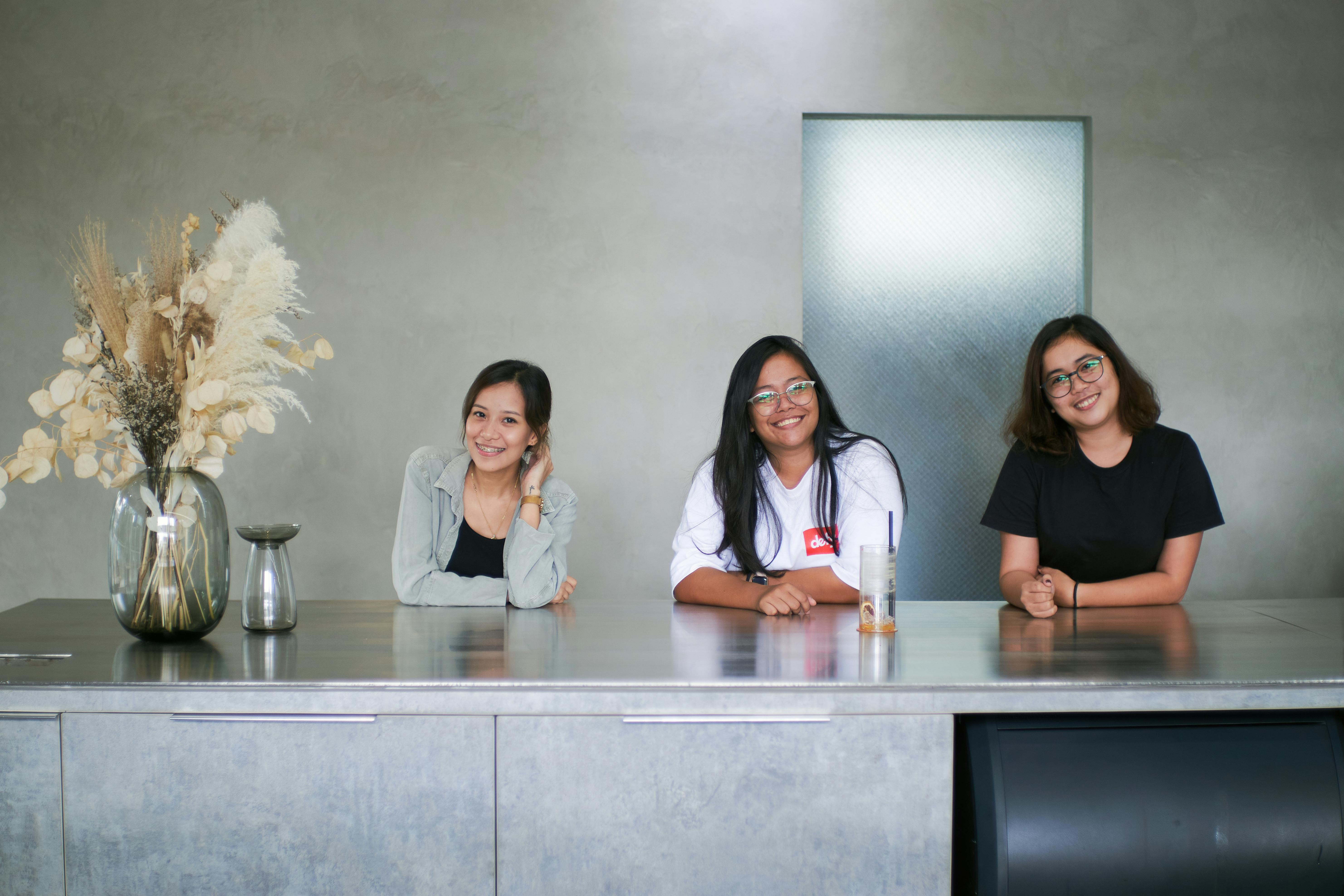 Smiling Women behind Table · Free Stock Photo