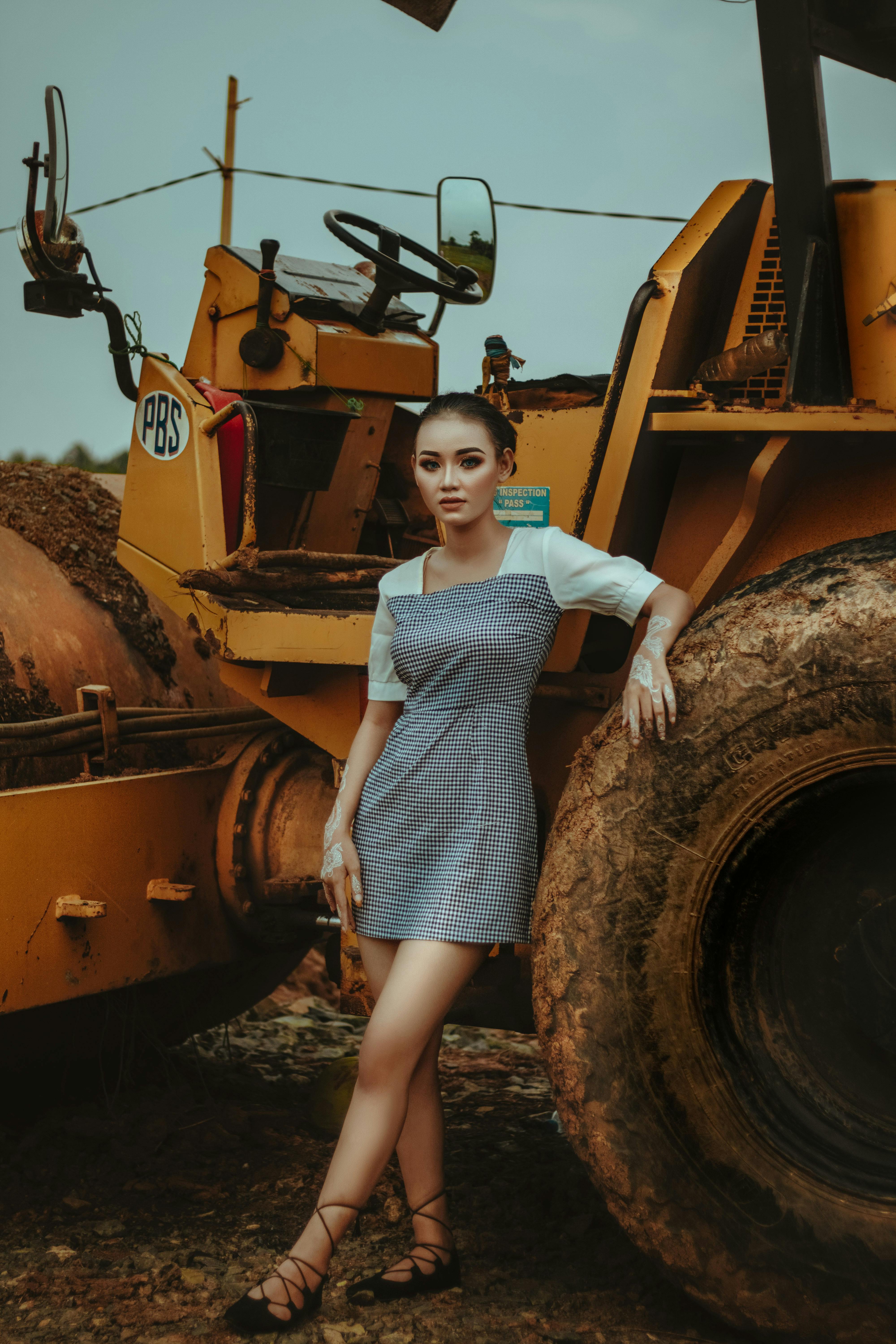 Young Woman Posing in front of a Bulldozer · Free Stock Photo