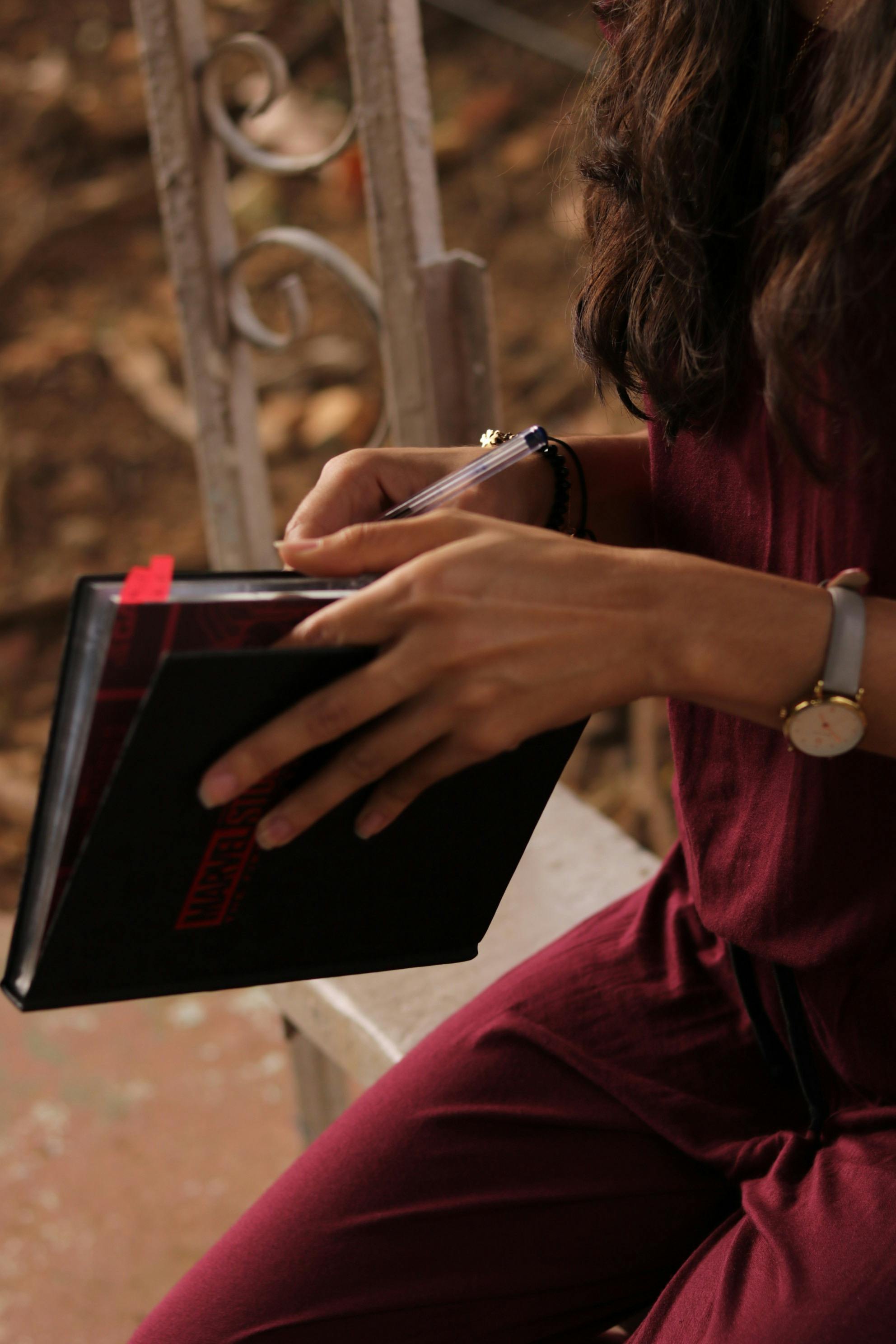 Close Up Photo of Person Holding Notebook and a Pen · Free Stock Photo