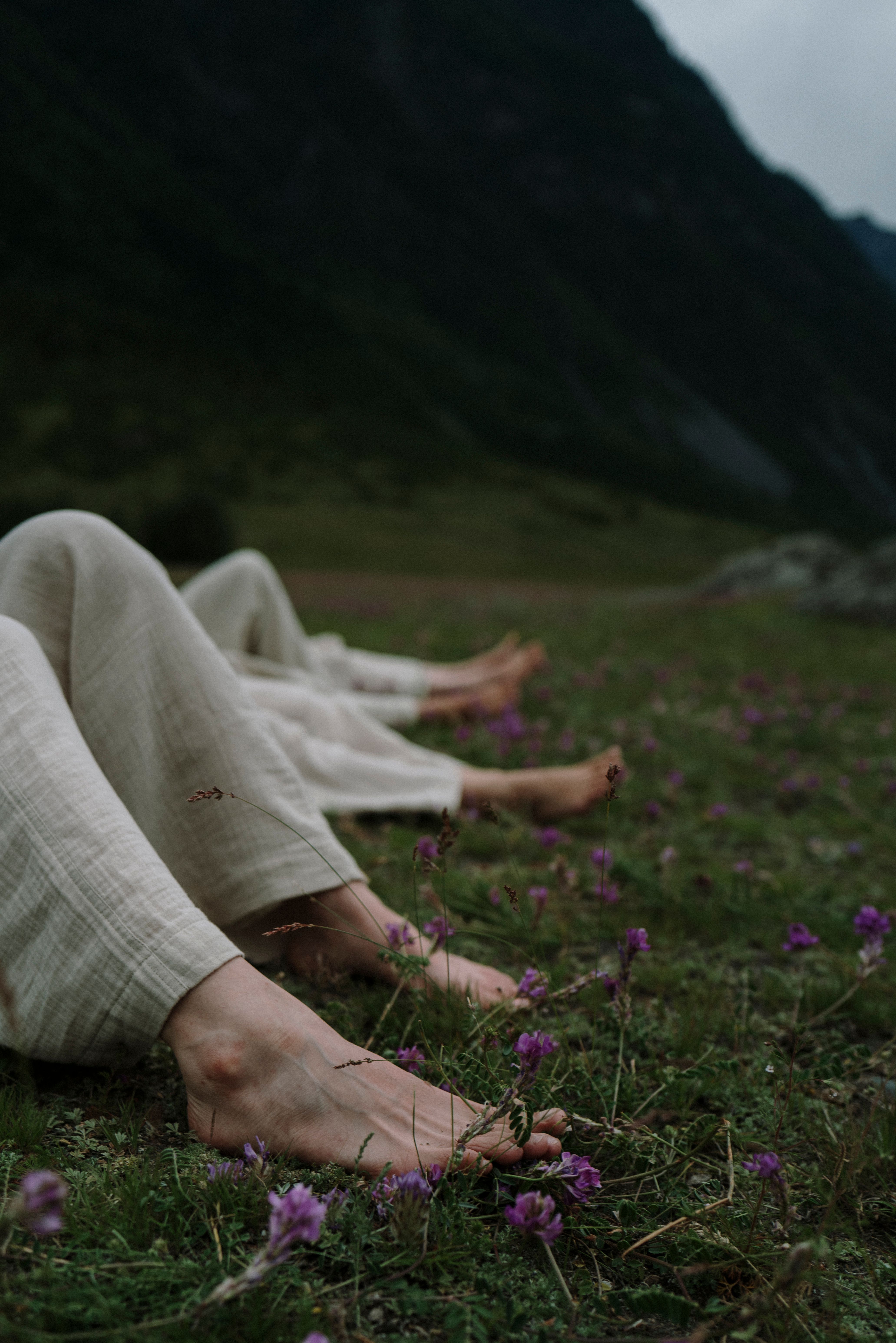 Feet of People Lying on the Grass Field · Free Stock Photo