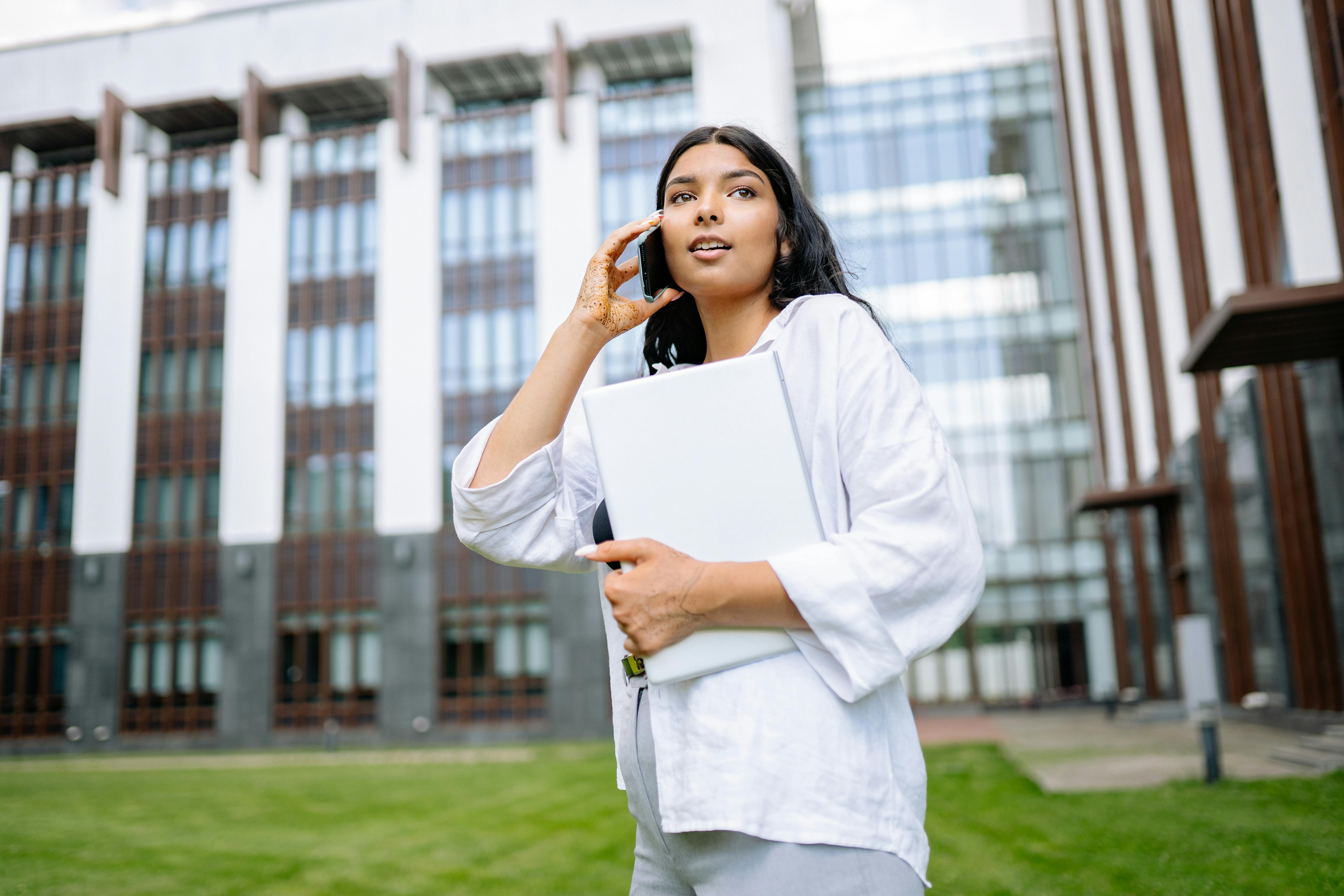 Woman Standing Using a Cellphone · Free Stock Photo