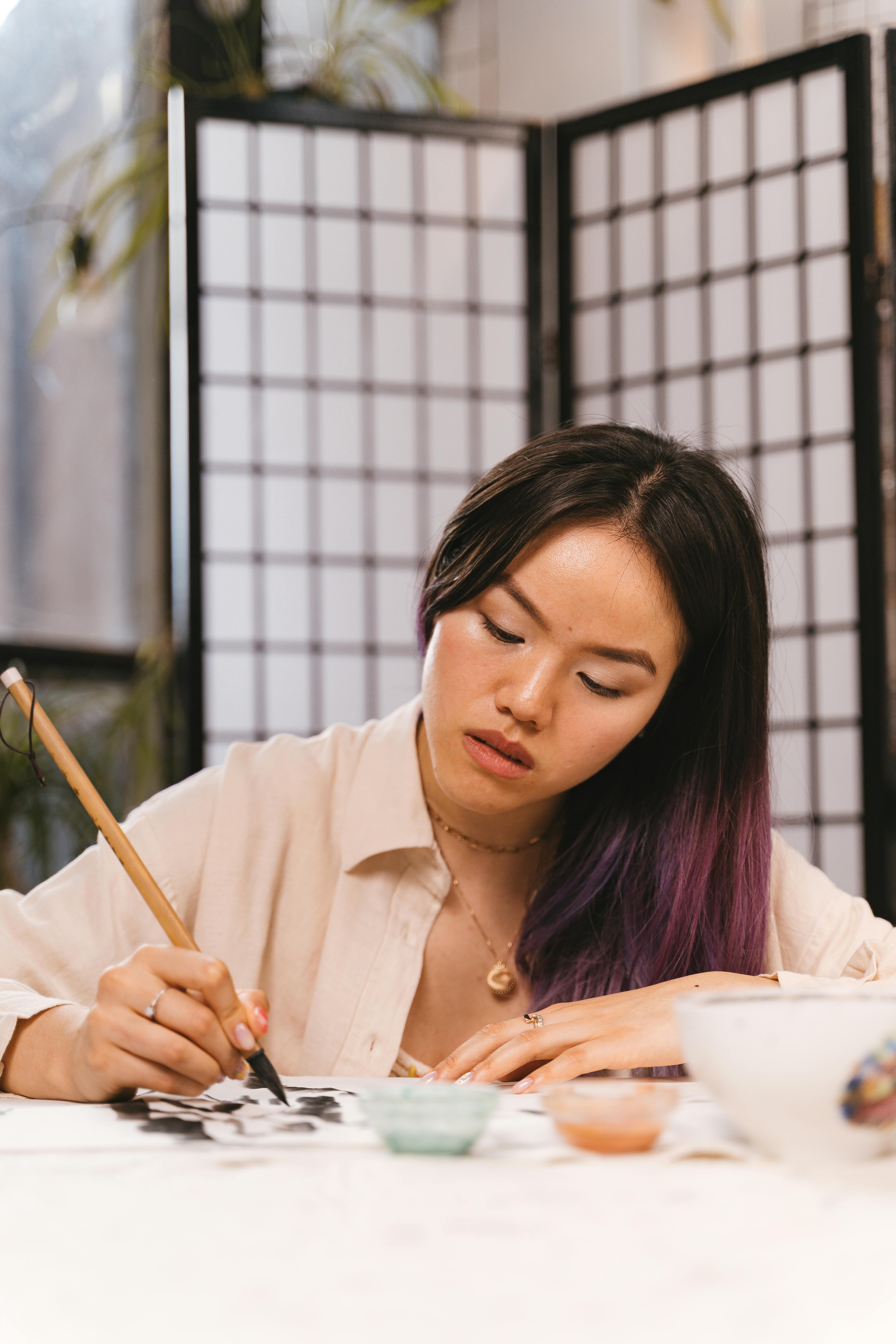 Woman Drawing using a Paintbrush · Free Stock Photo