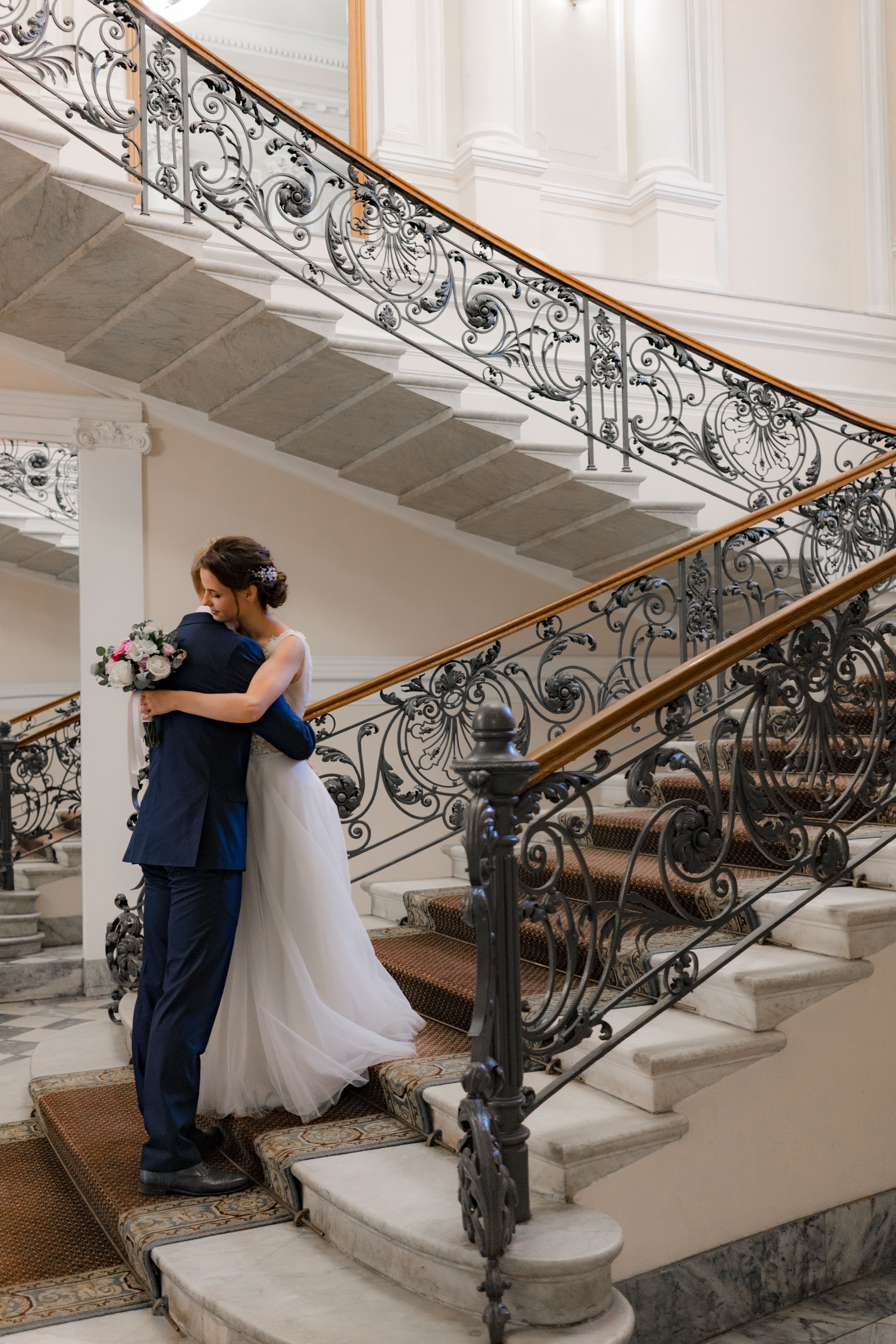 A Bride and Groom Hugging in the Staircase · Free Stock Photo