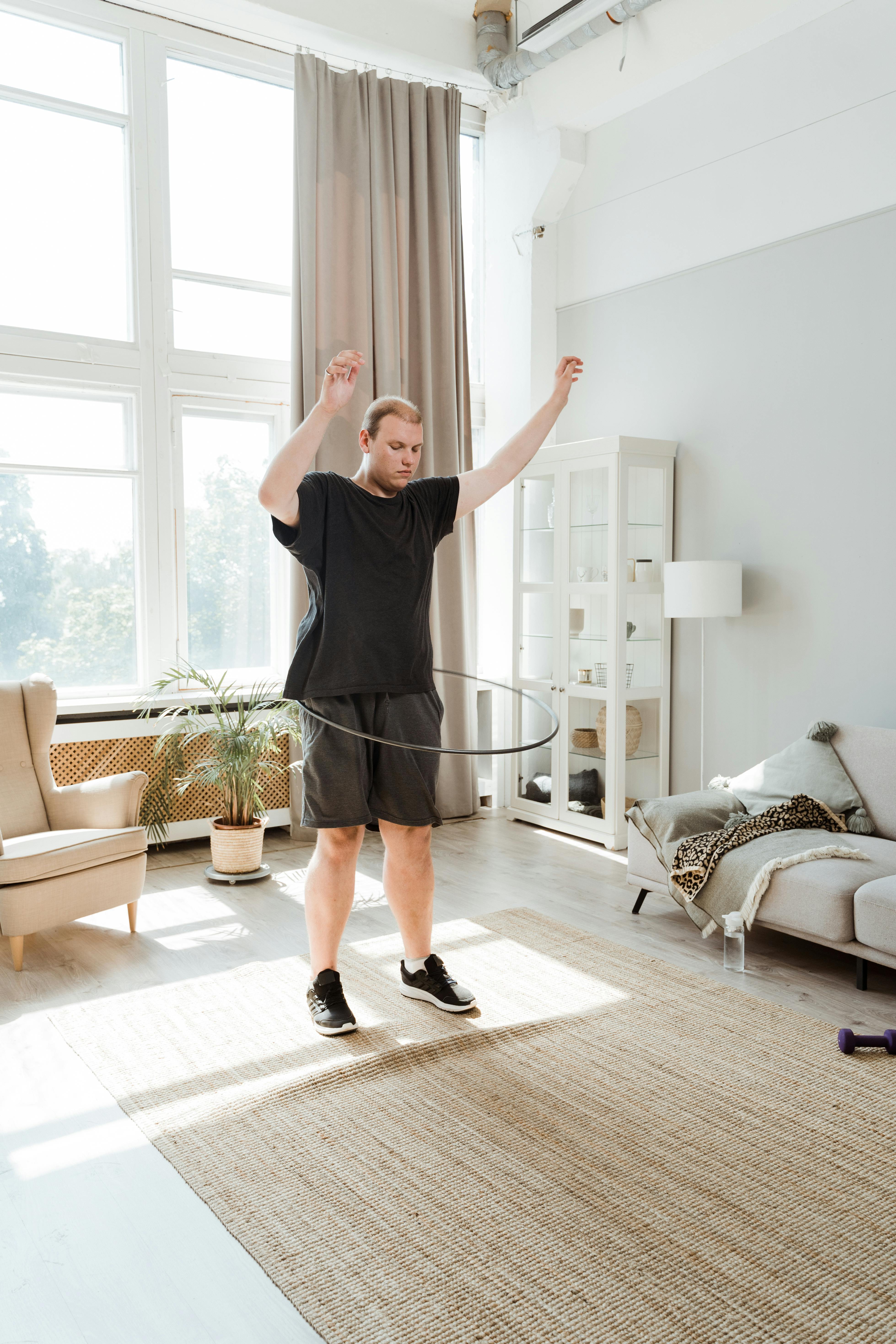 A Man in Black Active Wear Using a Hula Hoop · Free Stock Photo