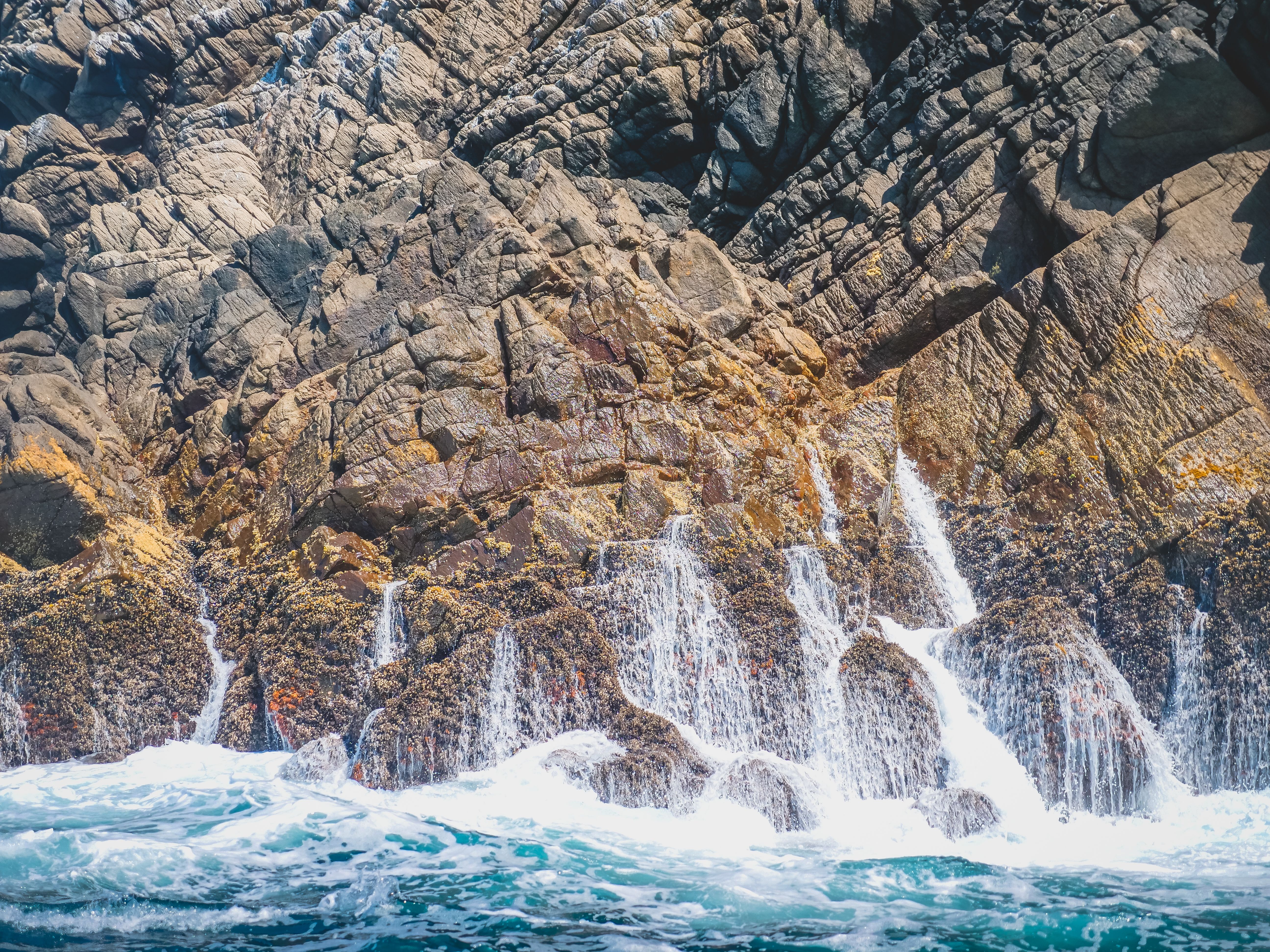 Water Falls on Rocky Coastal Mountain · Free Stock Photo