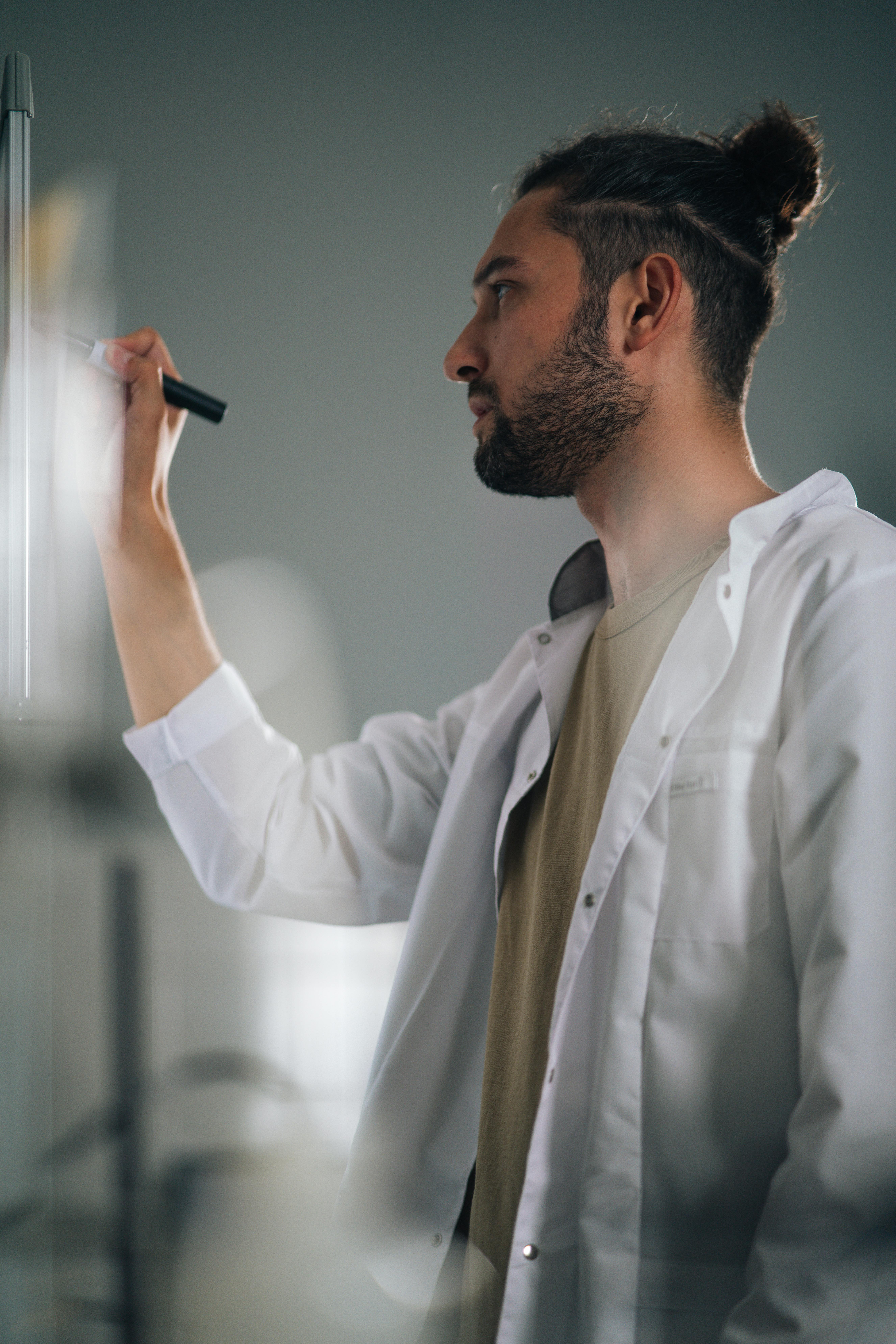 Young Man Wearing Lab Coat Writing Formula on White Board · Free Stock ...