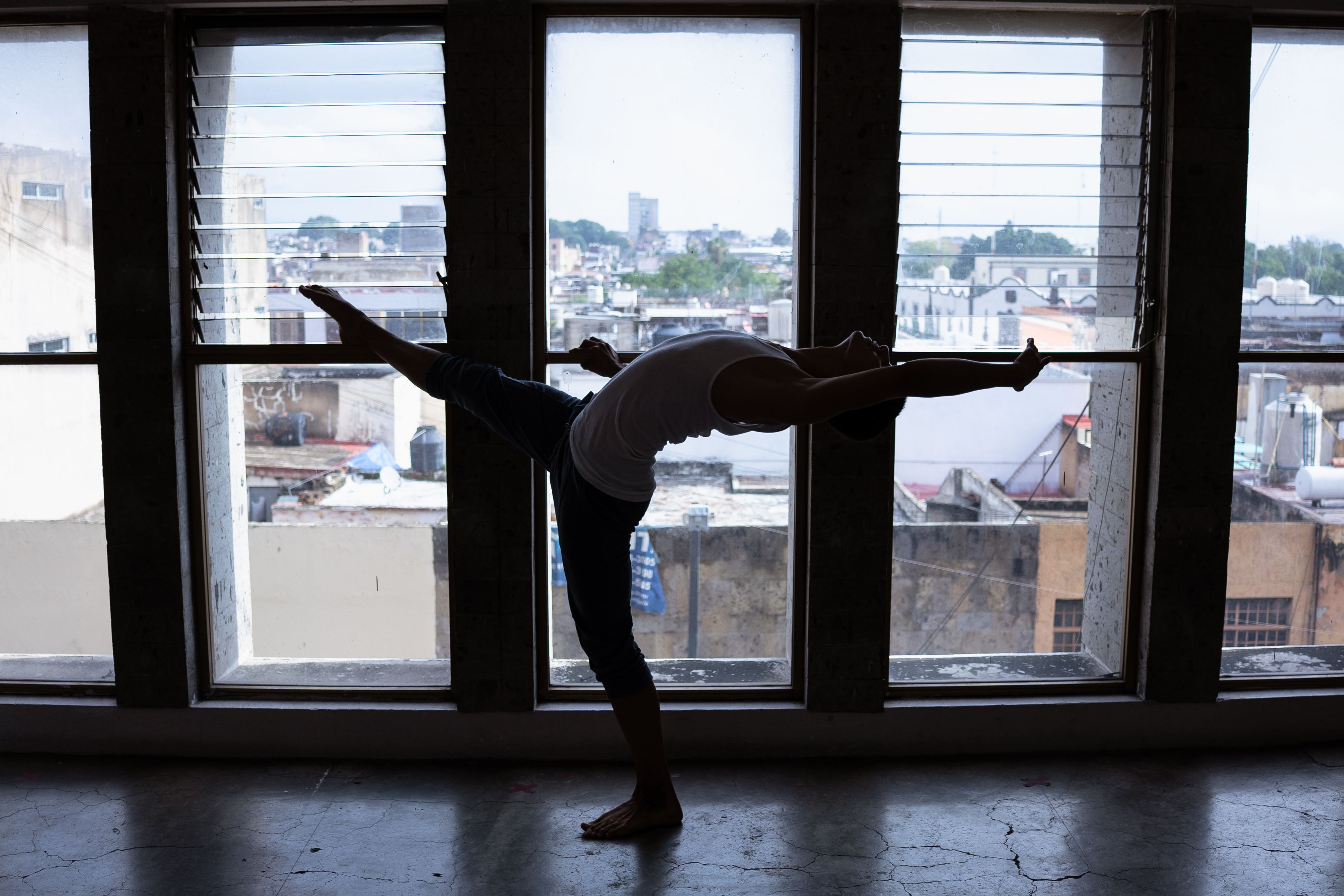 Man Bending His Body Near Windows · Free Stock Photo