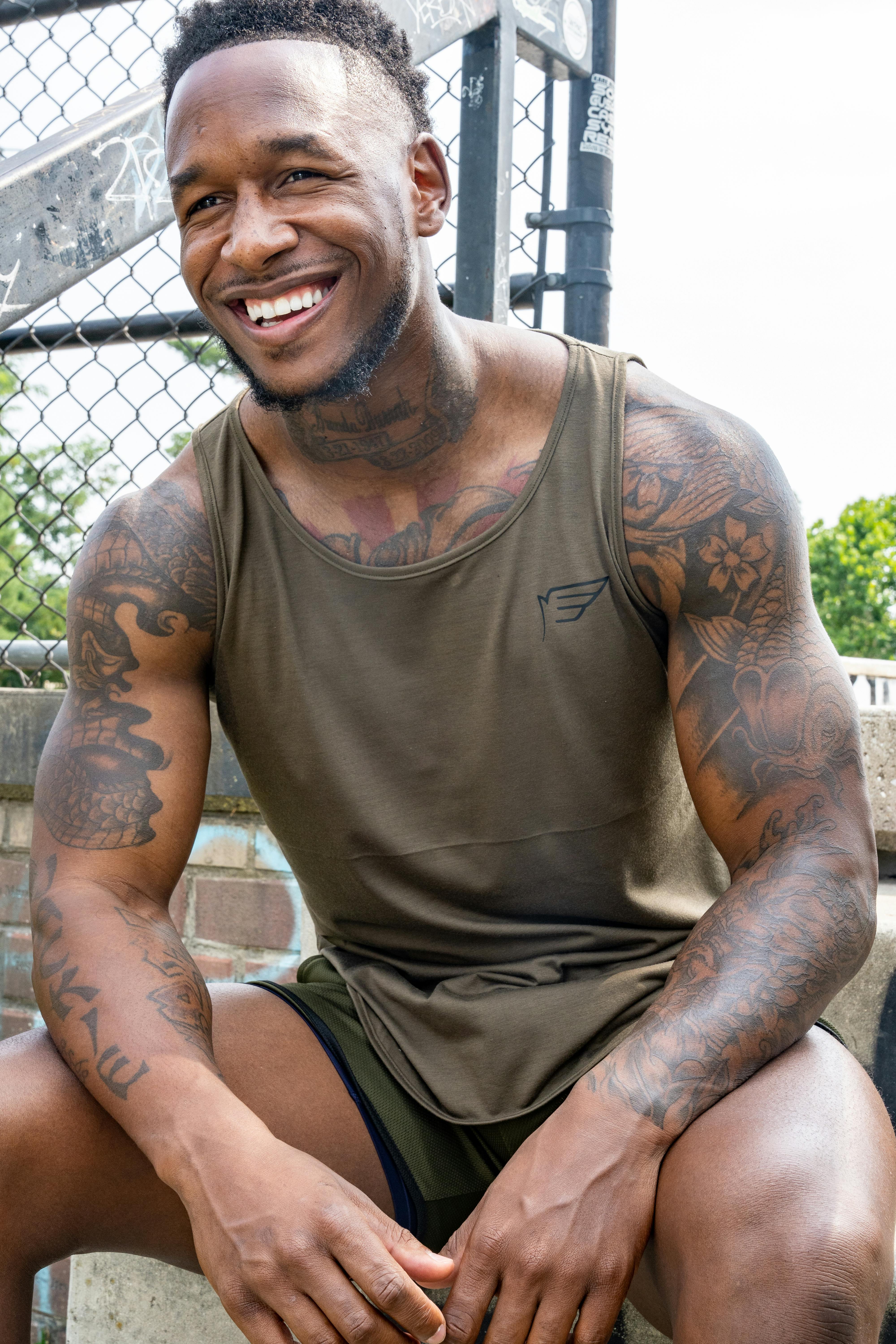 Man in a Green Tank Top Smiling · Free Stock Photo