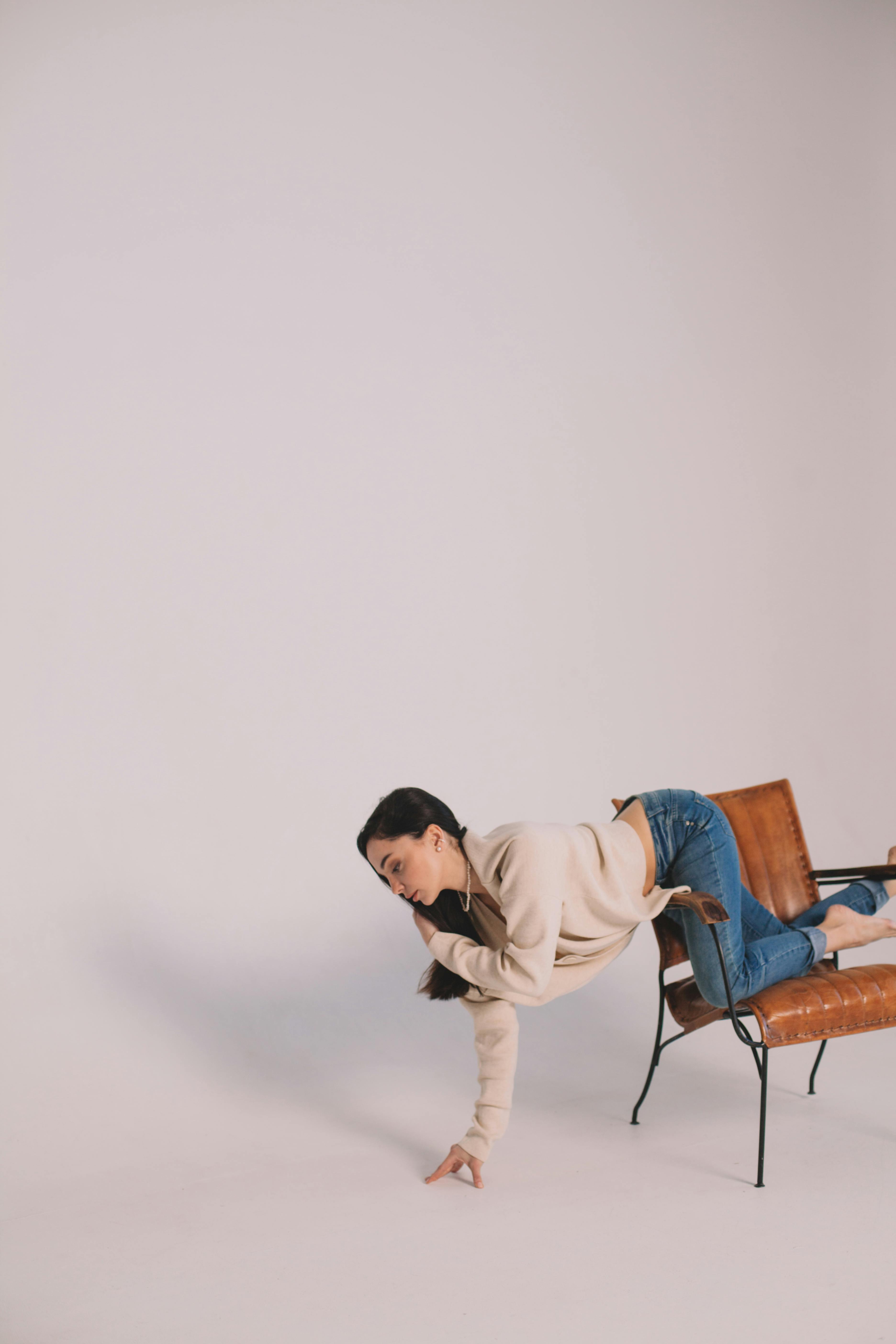 Woman in Jeans Kneeling on Ground · Free Stock Photo
