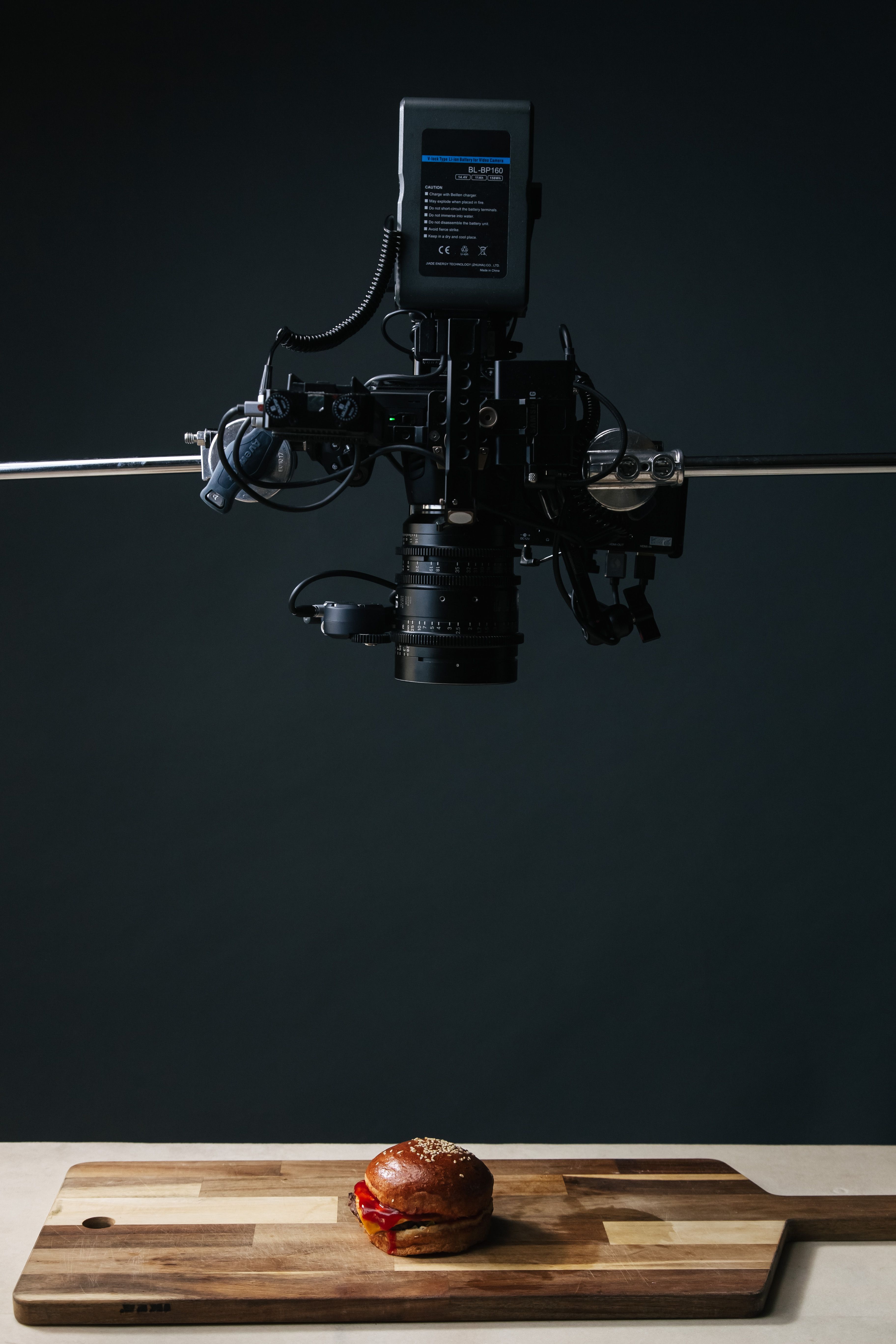 Professional Camera above a Bun Lying on a Cutting Board · Free Stock Photo