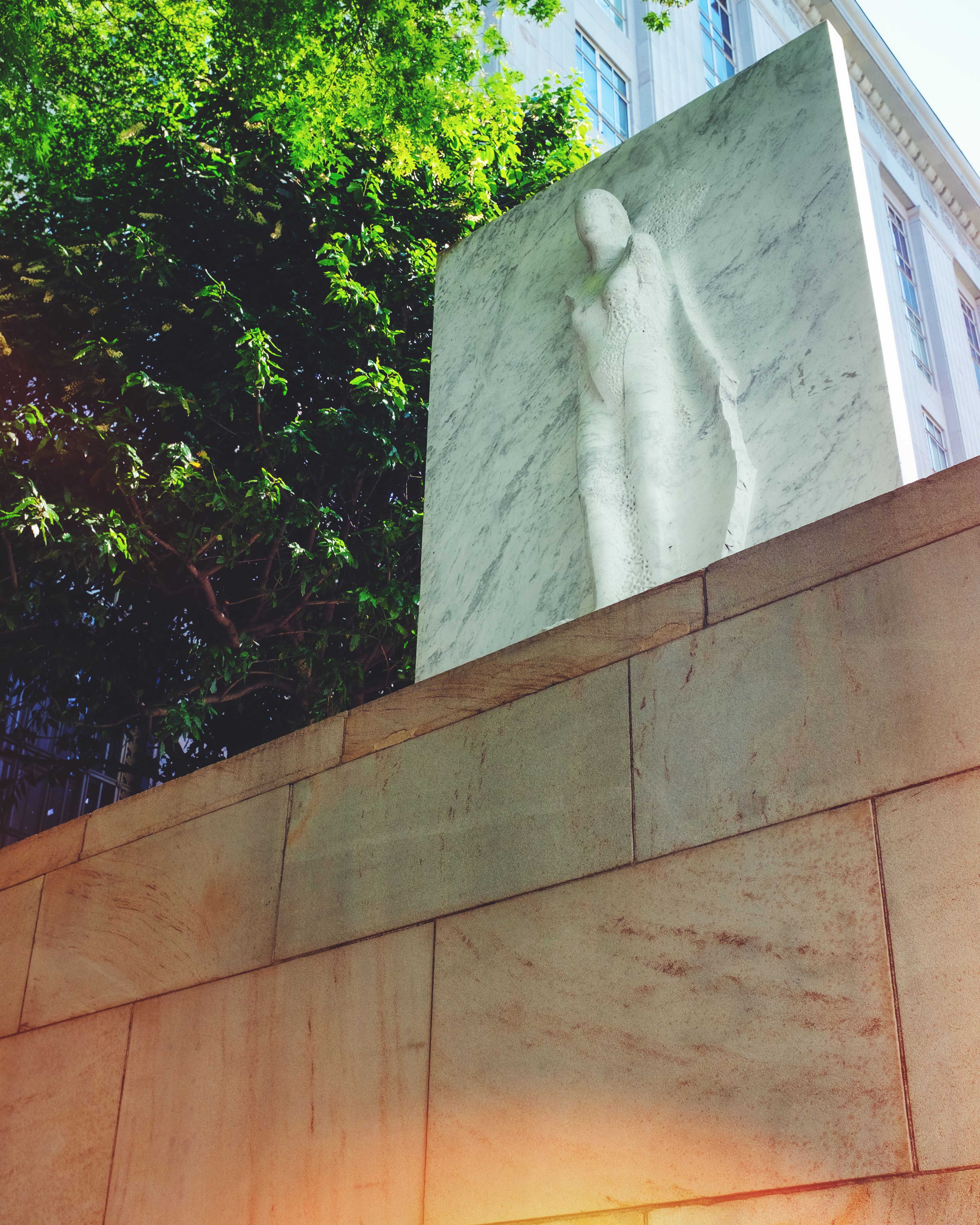 Sculpture Emerging From a Building Wall · Free Stock Photo