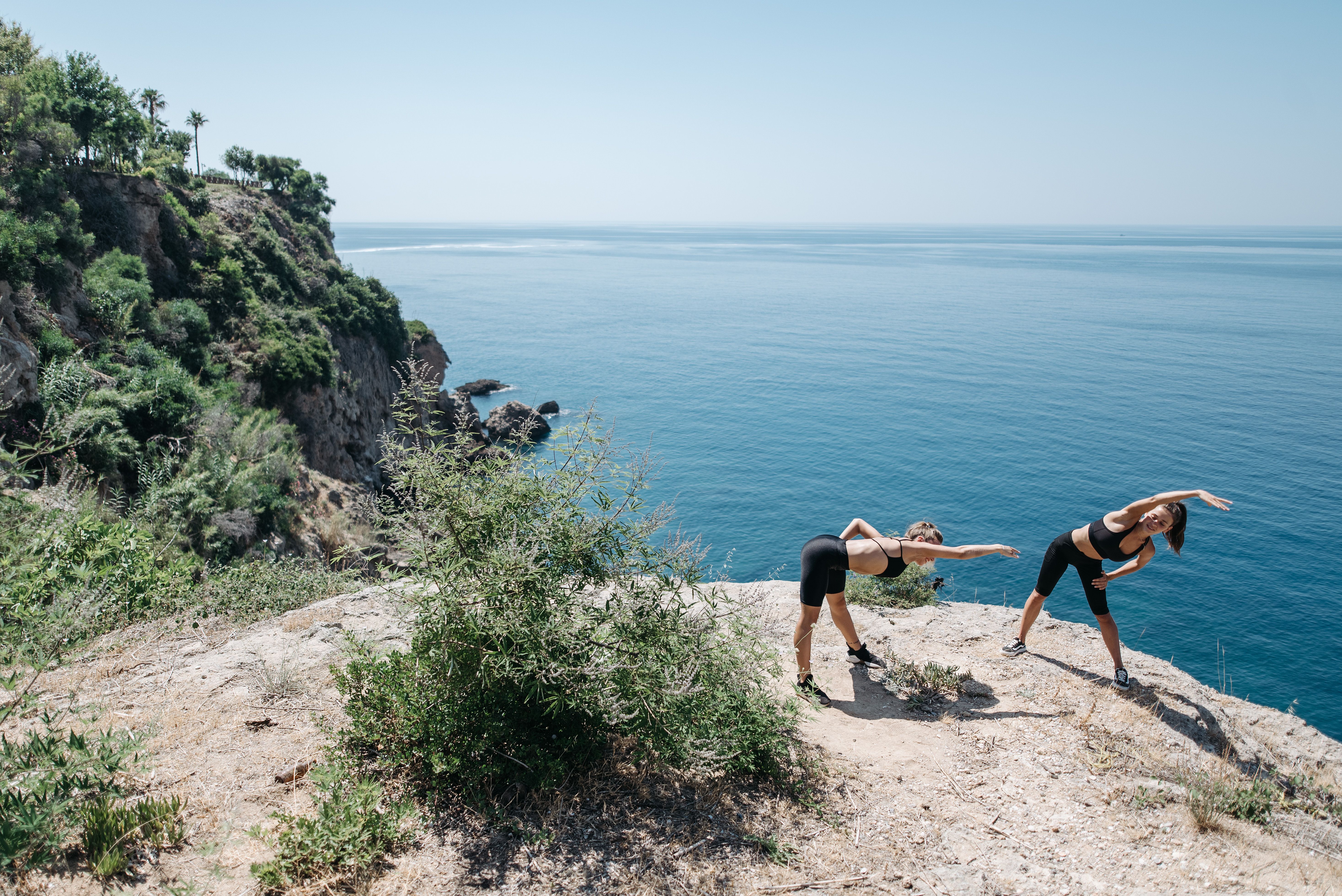 Women Doing Stretchings on a Cliff · Free Stock Photo