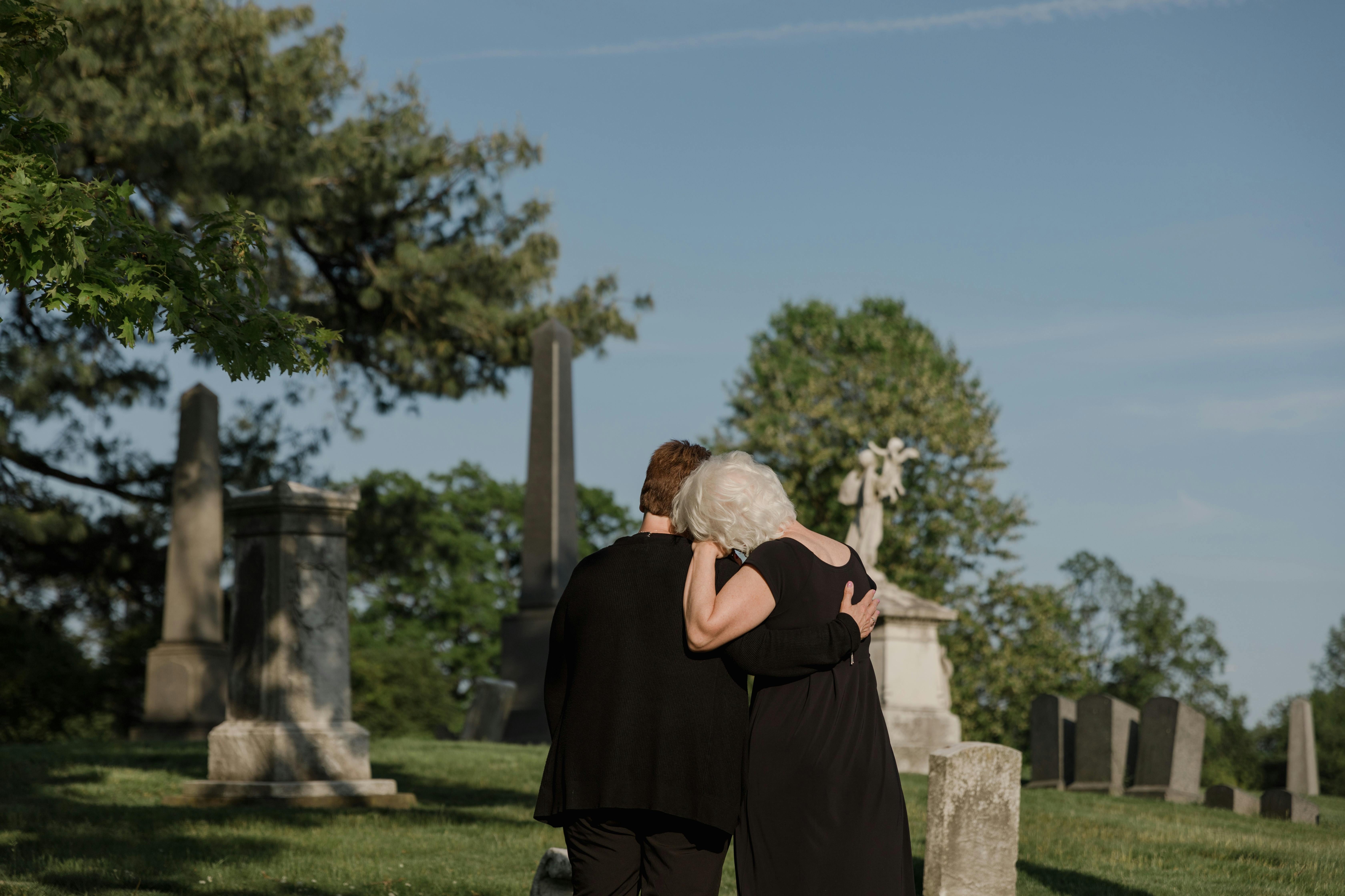 A Man Smoking a Cigarette while Sitting on a Grave · Free Stock Photo