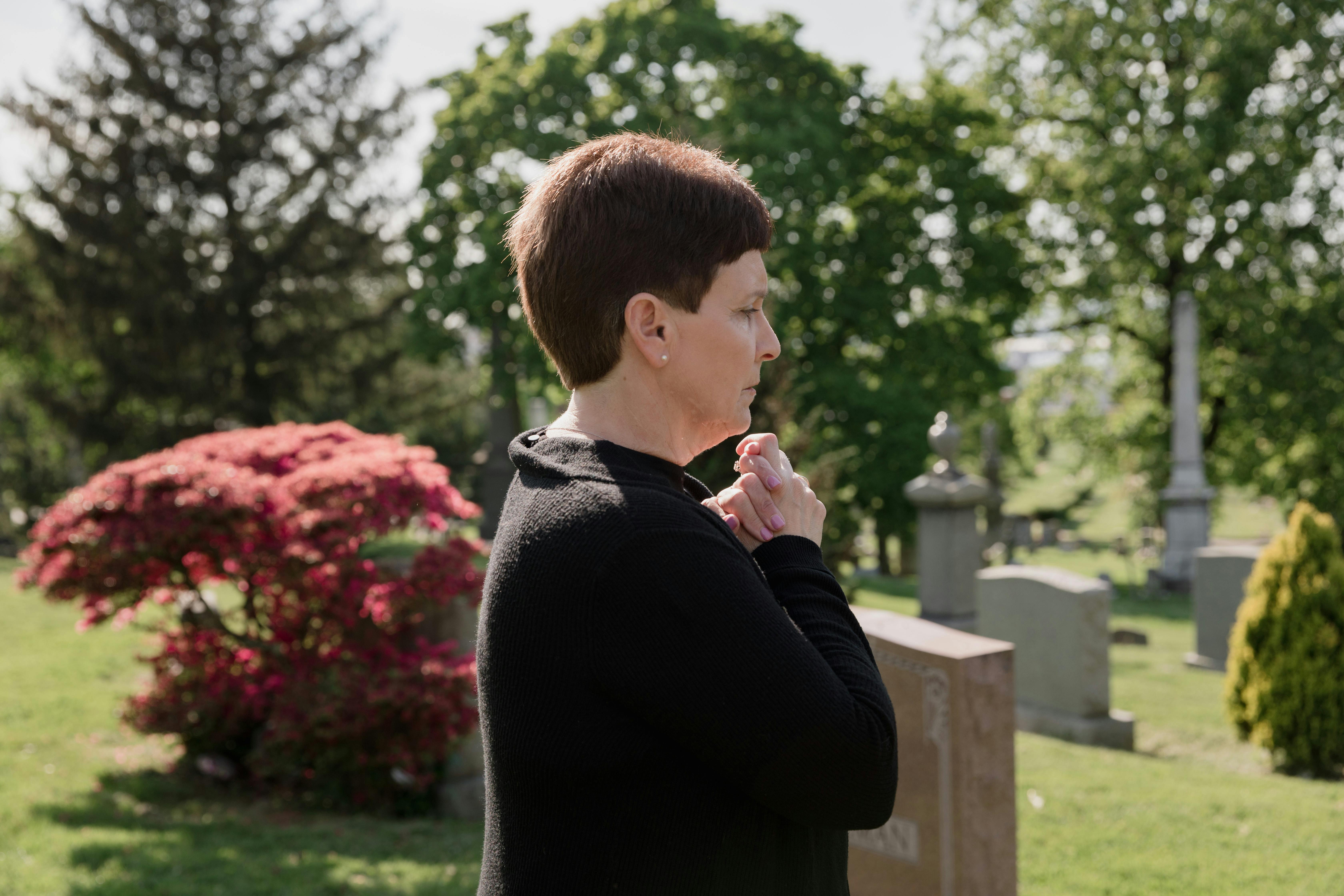 Photo of a Grieving Woman in a Cemetery · Free Stock Photo