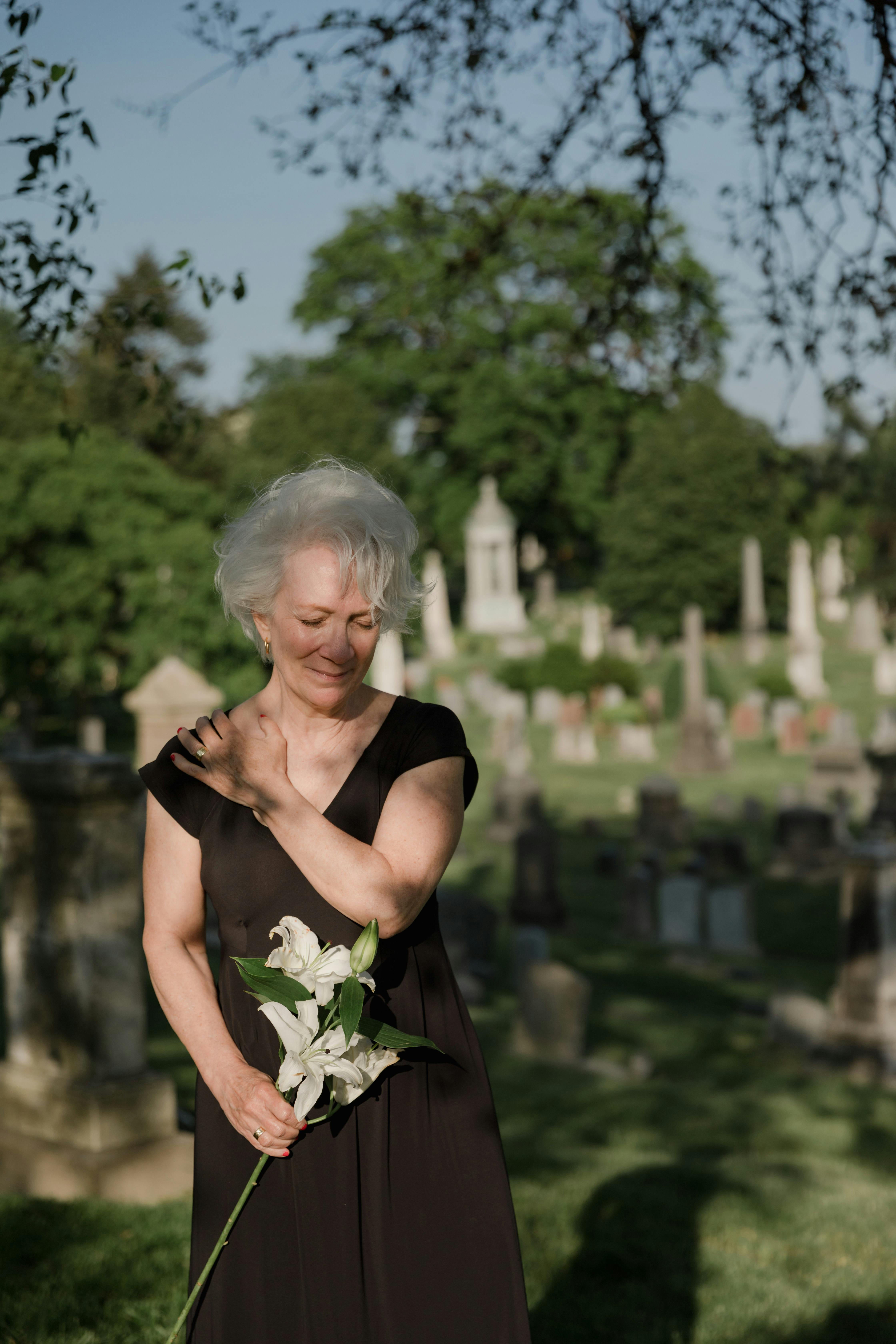 Closeup of a Widow Holding a Red Rose · Free Stock Photo
