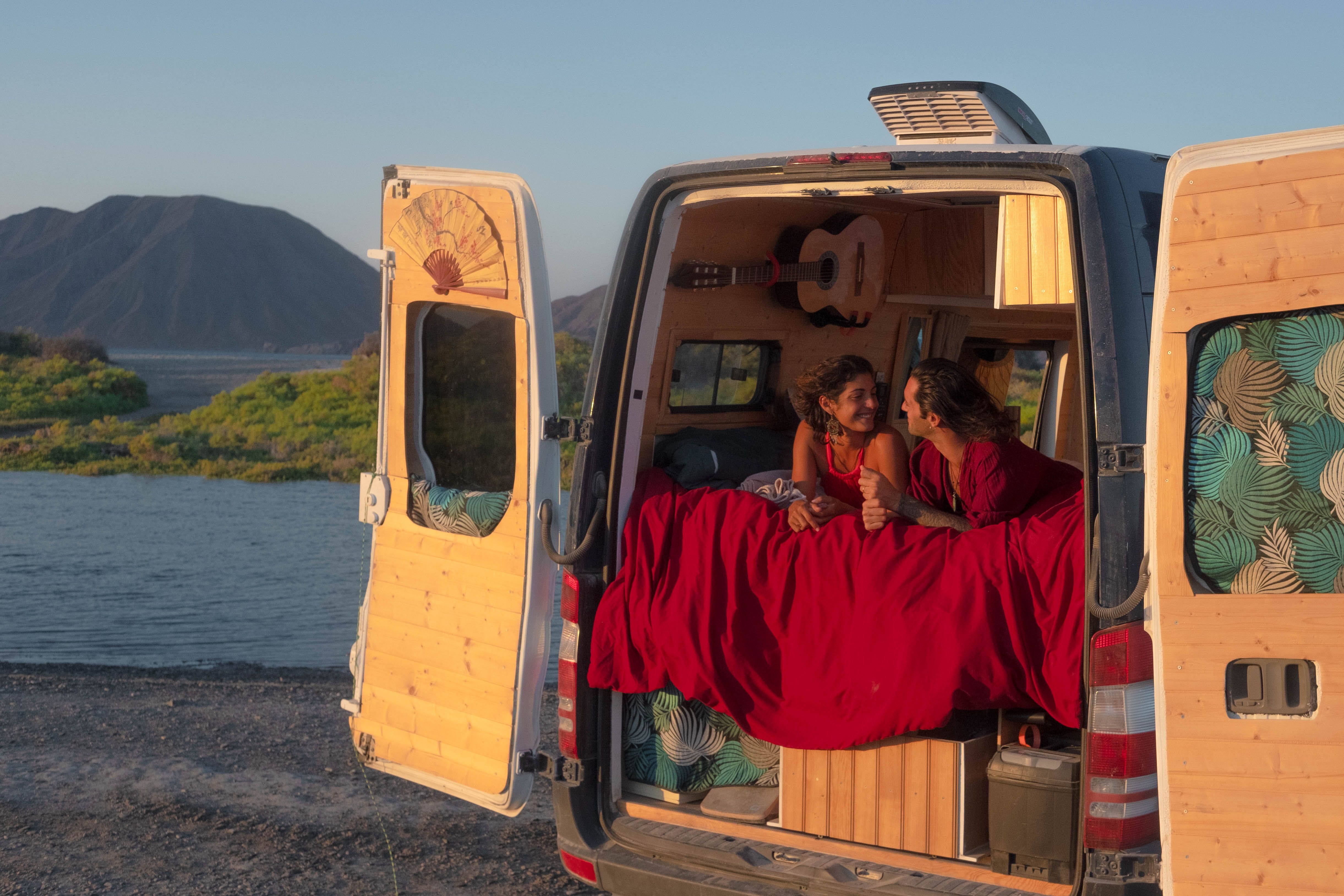 Happy friends on camper van roof · Free Stock Photo