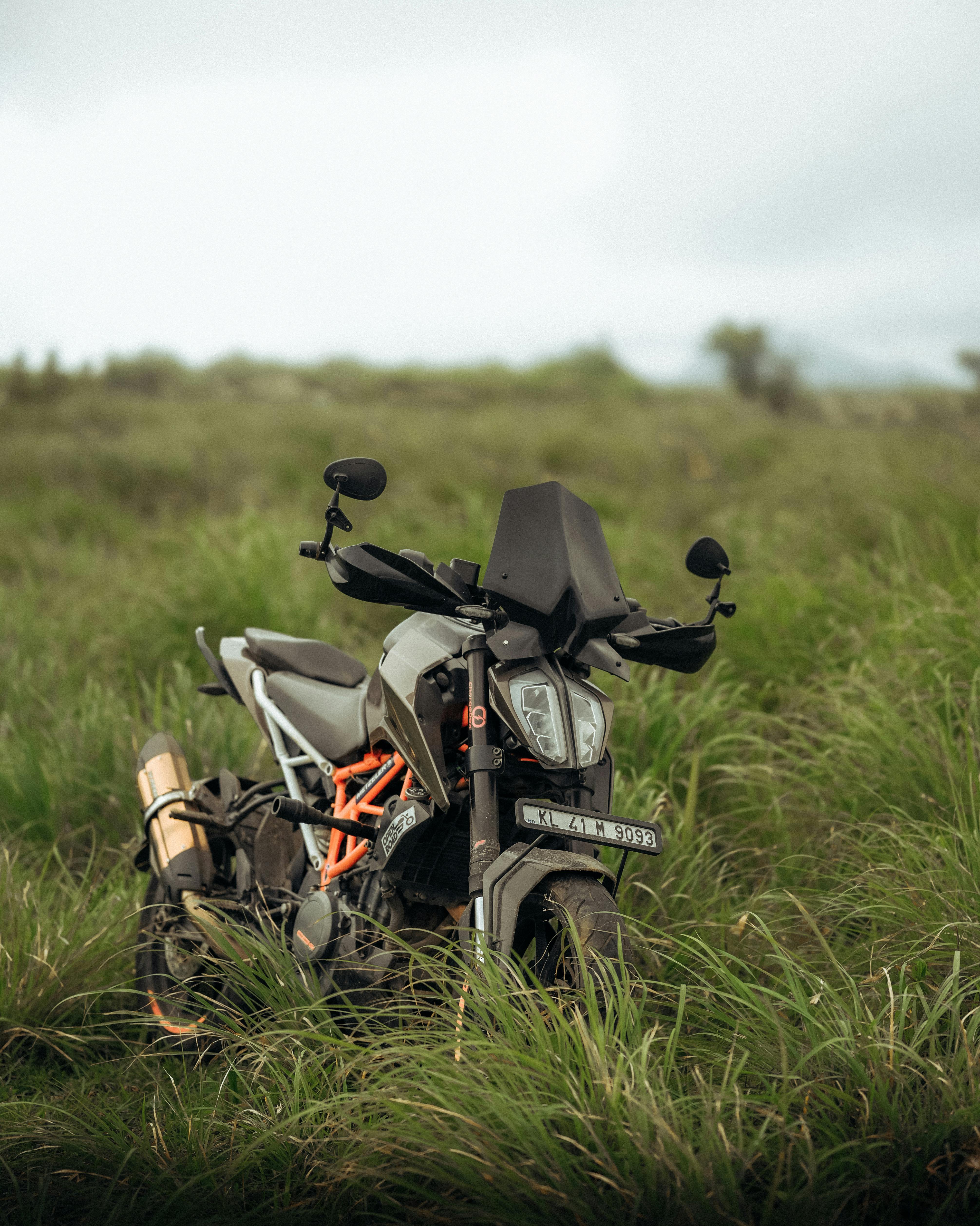 A Black Motorcycle in a Grass Field · Free Stock Photo