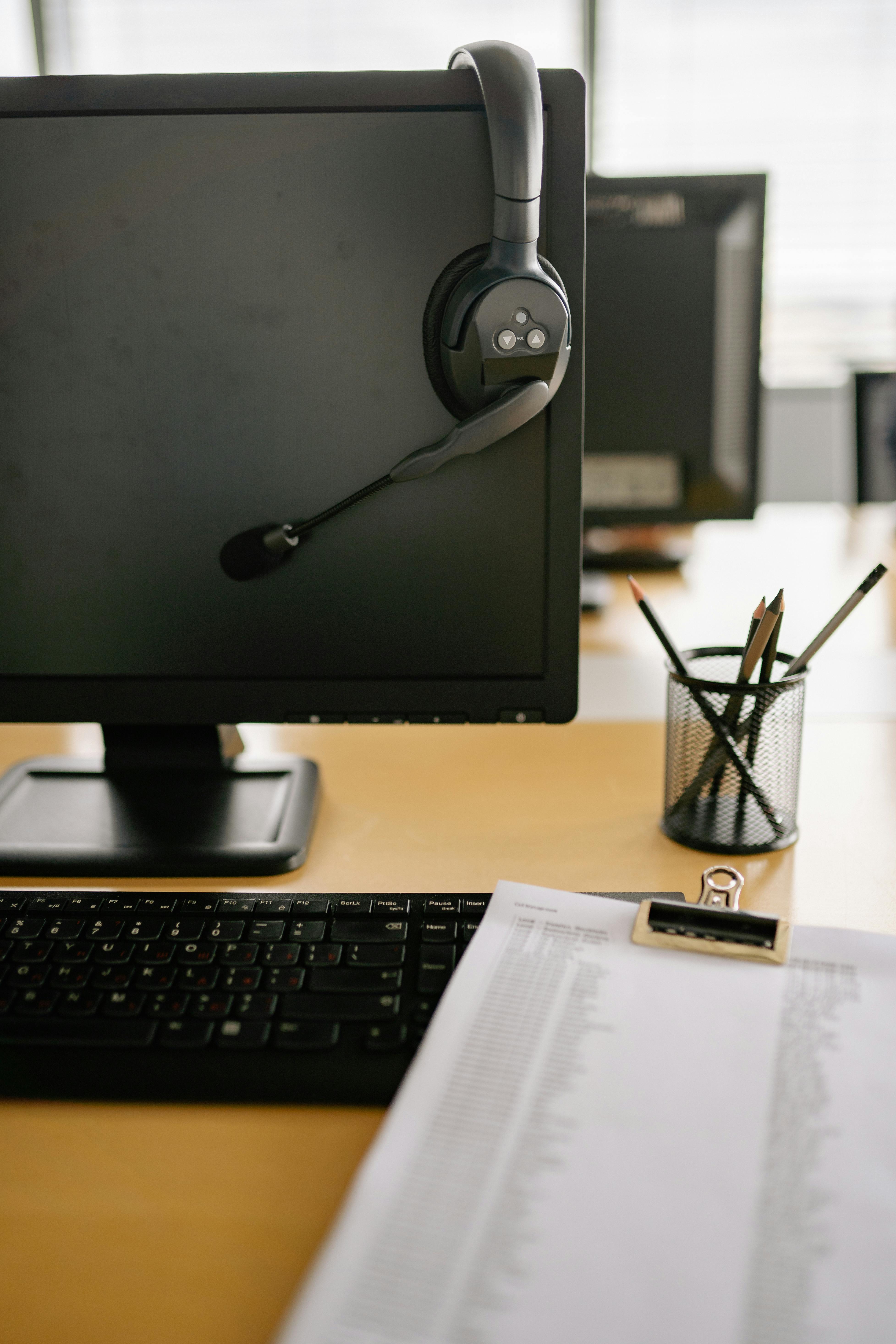 Black Headset Hanged on a Monitor · Free Stock Photo