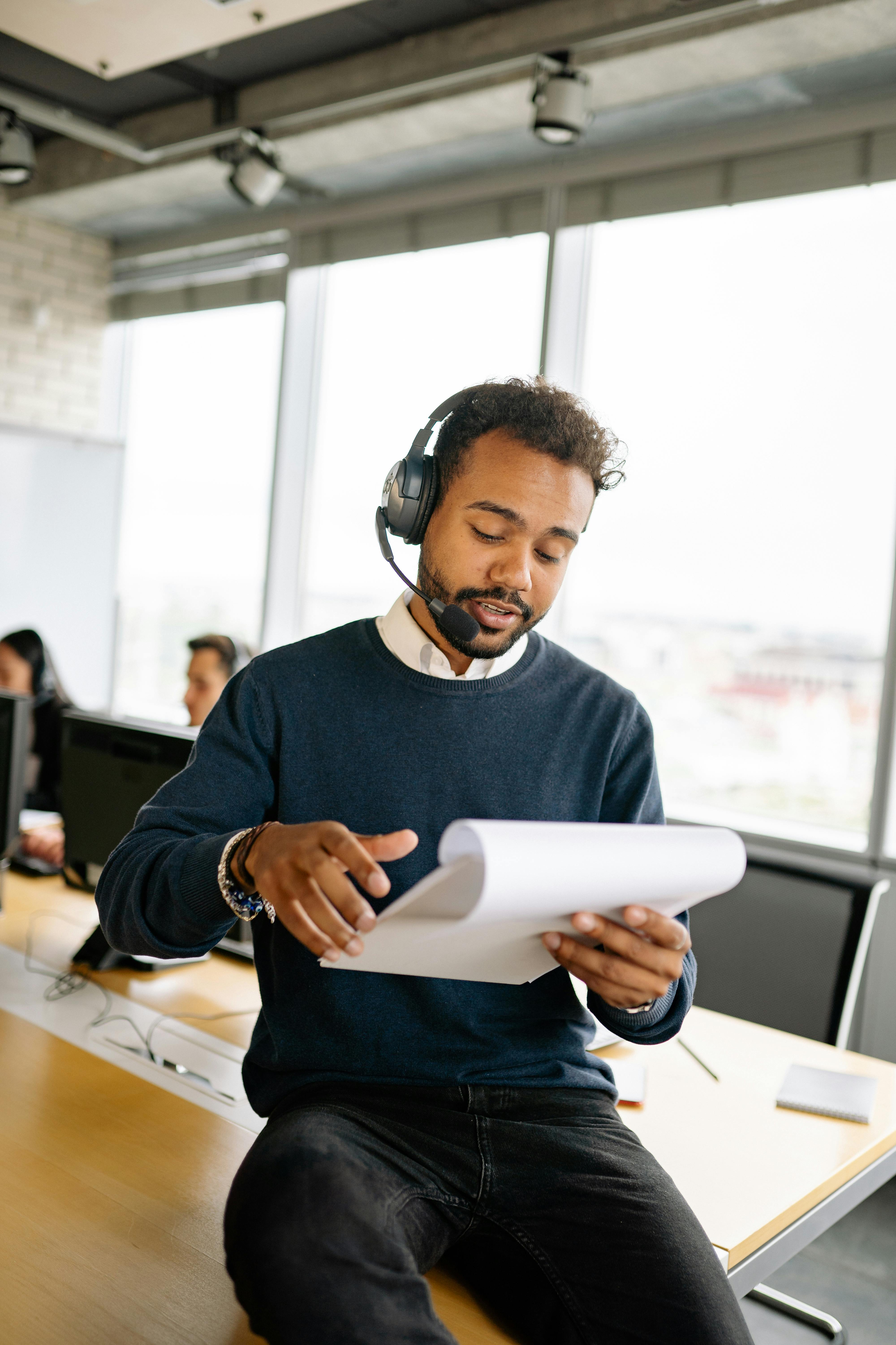 Man Using Headphones Holding a Paper · Free Stock Photo