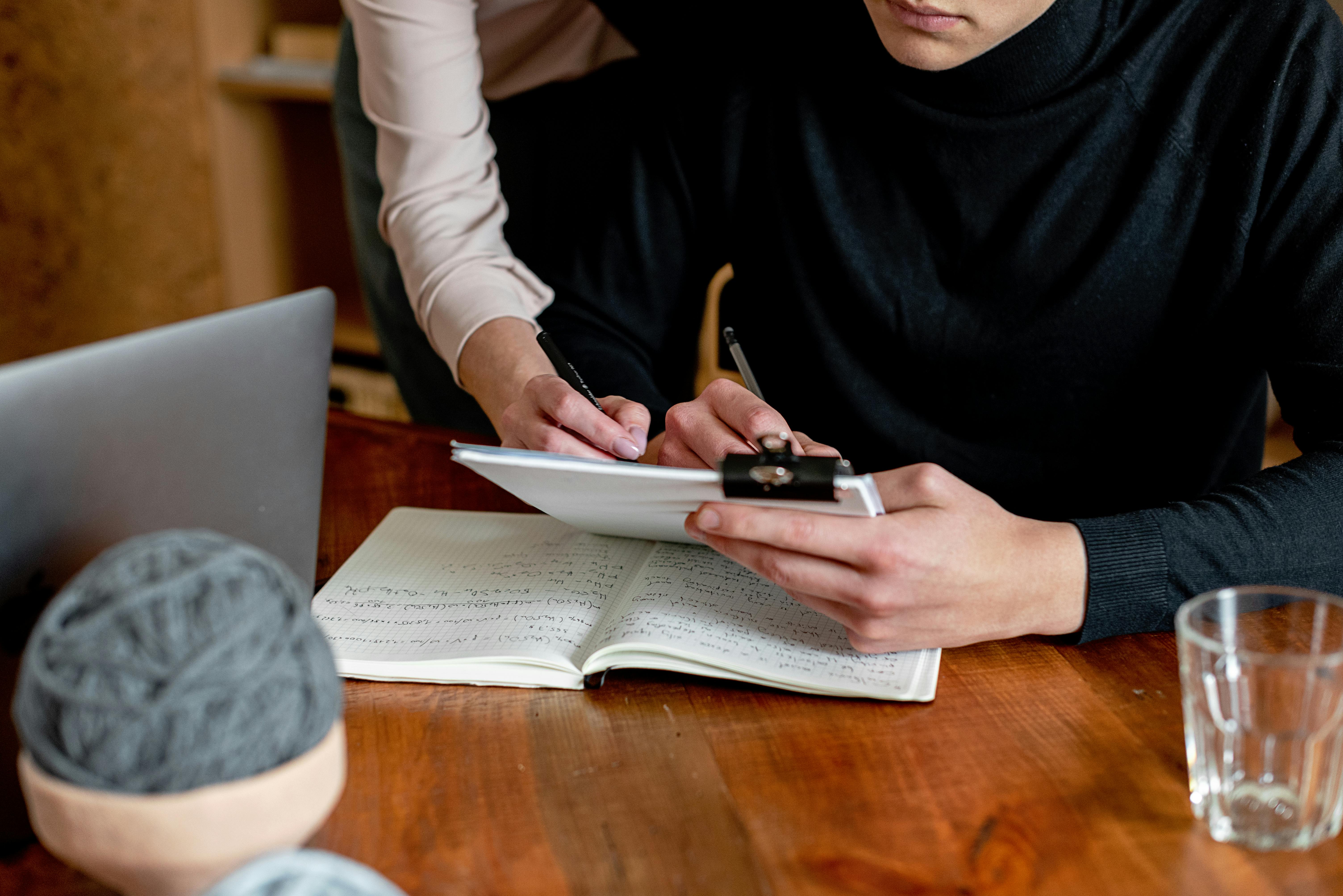 Woman over Man Writing on Table · Free Stock Photo