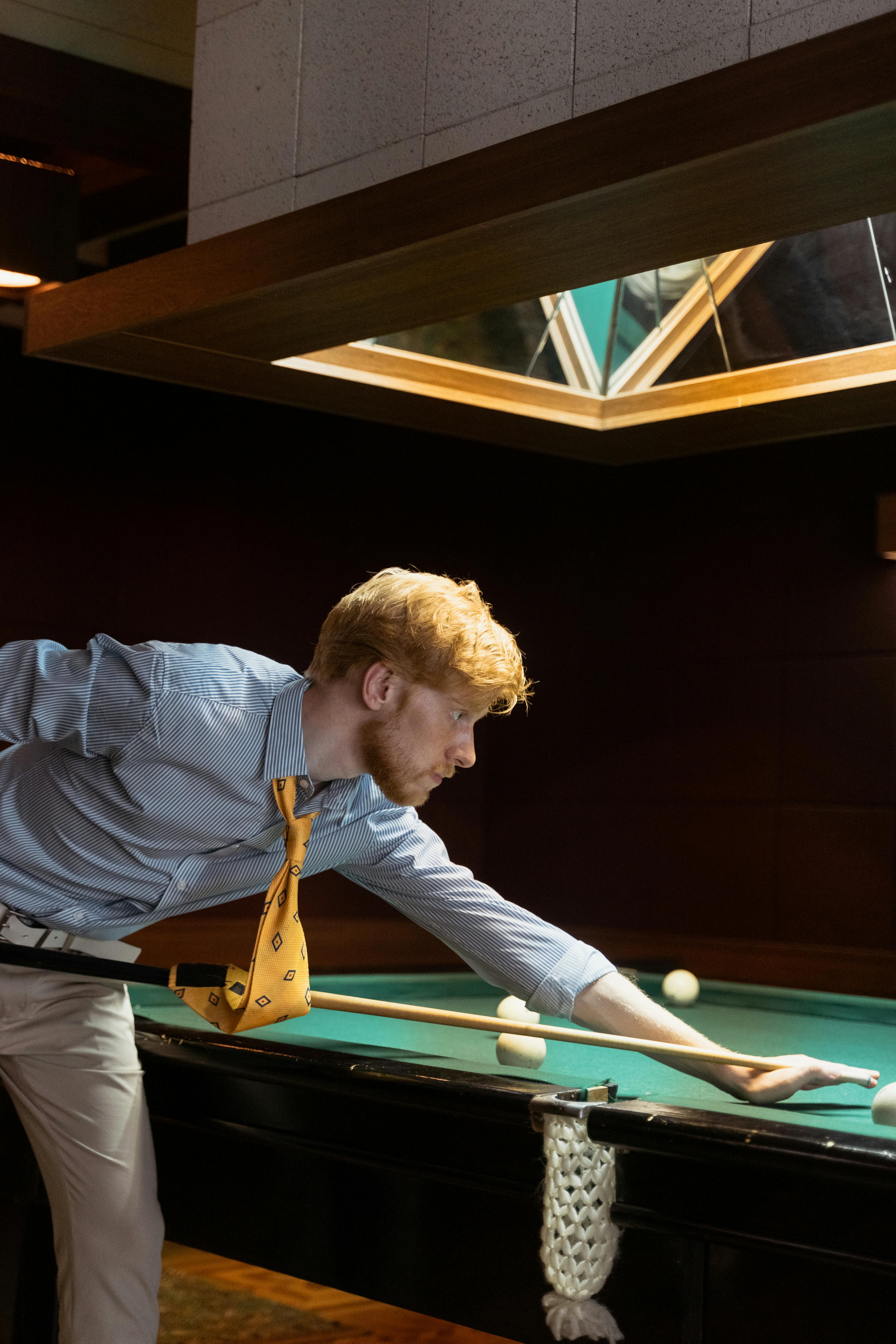 Man Playing Pool Table While Sharply Looking at the White Ball on the ...