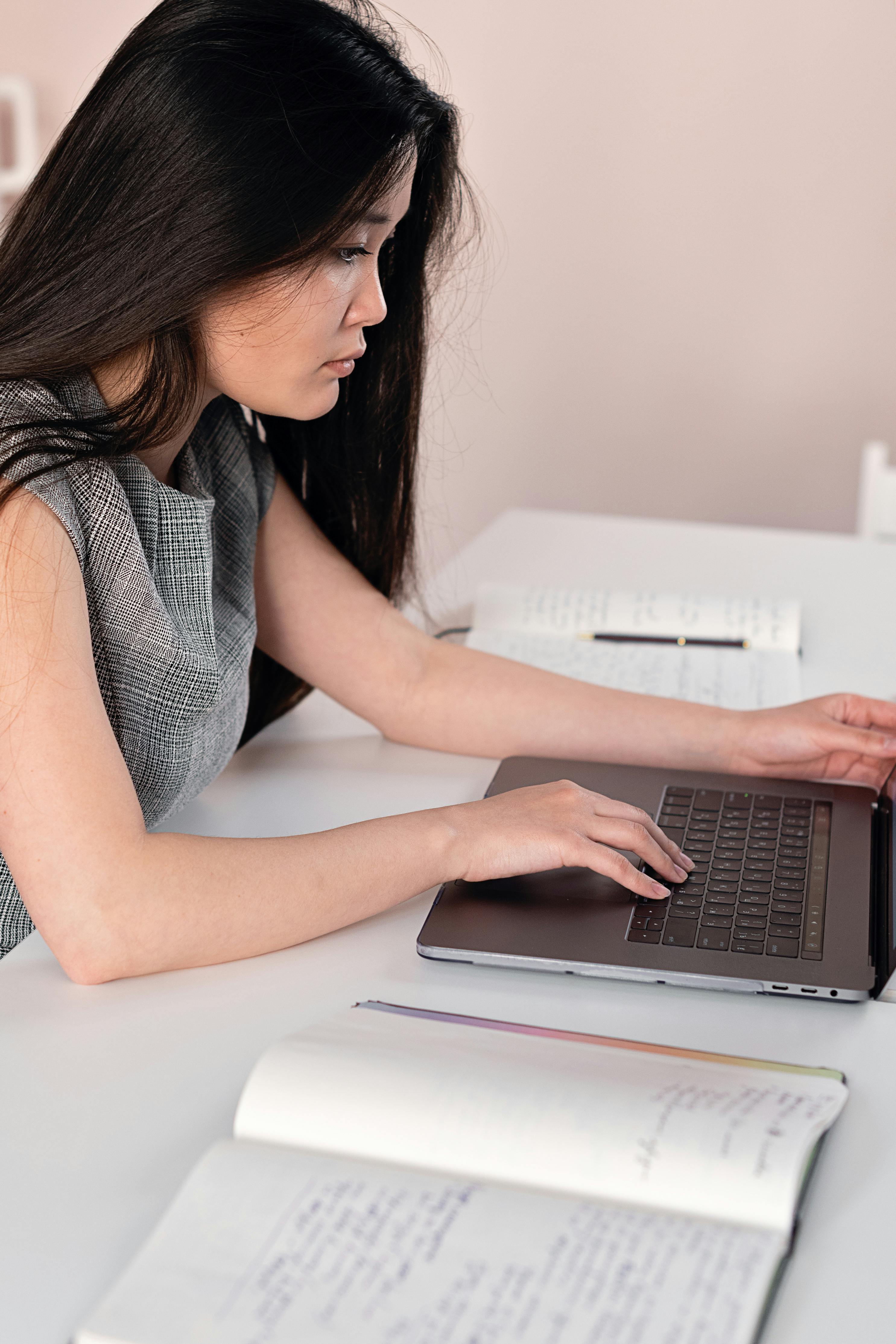 Side View of a Woman using Laptop · Free Stock Photo