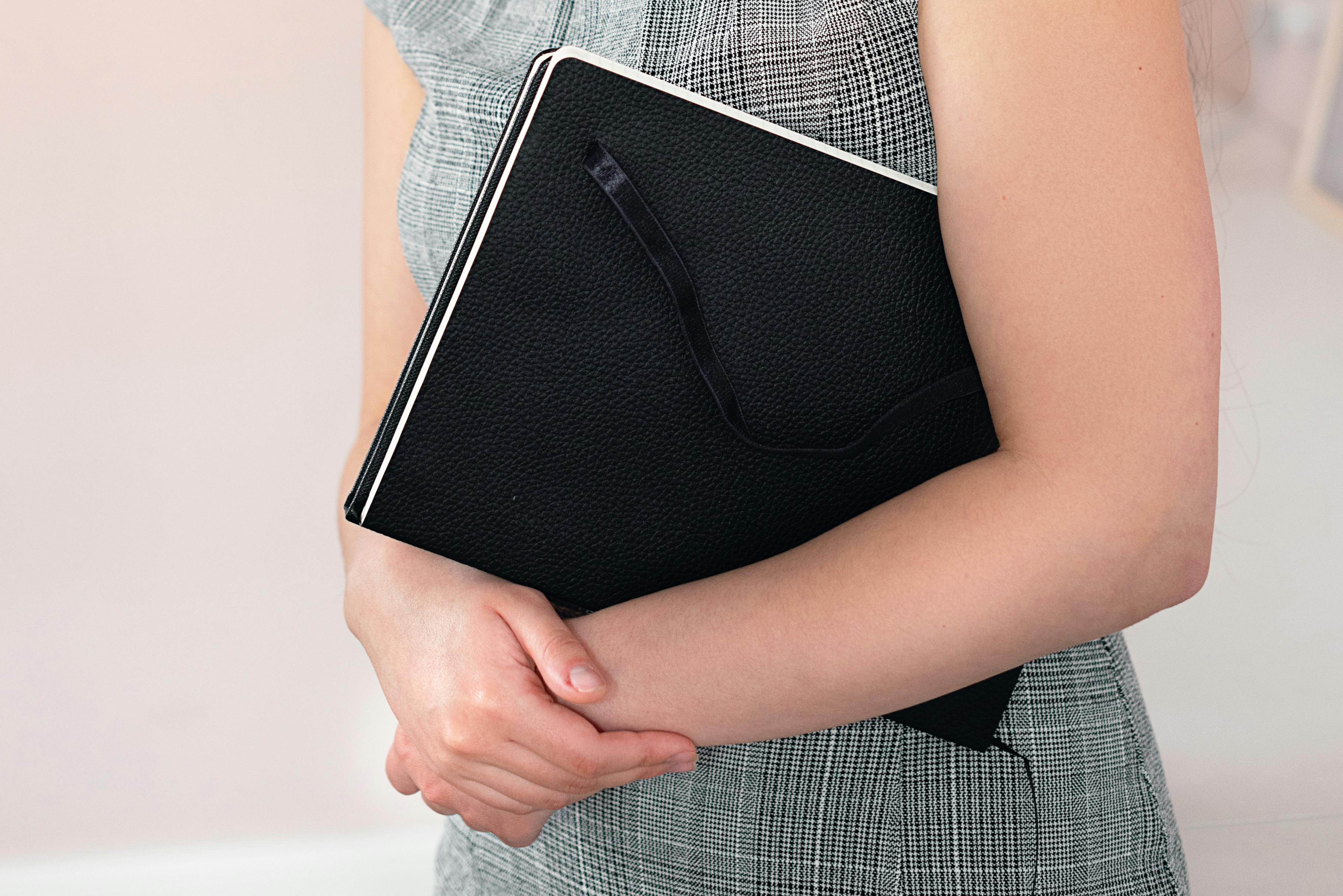 Photo of a Woman Holding a Black Notebook · Free Stock Photo