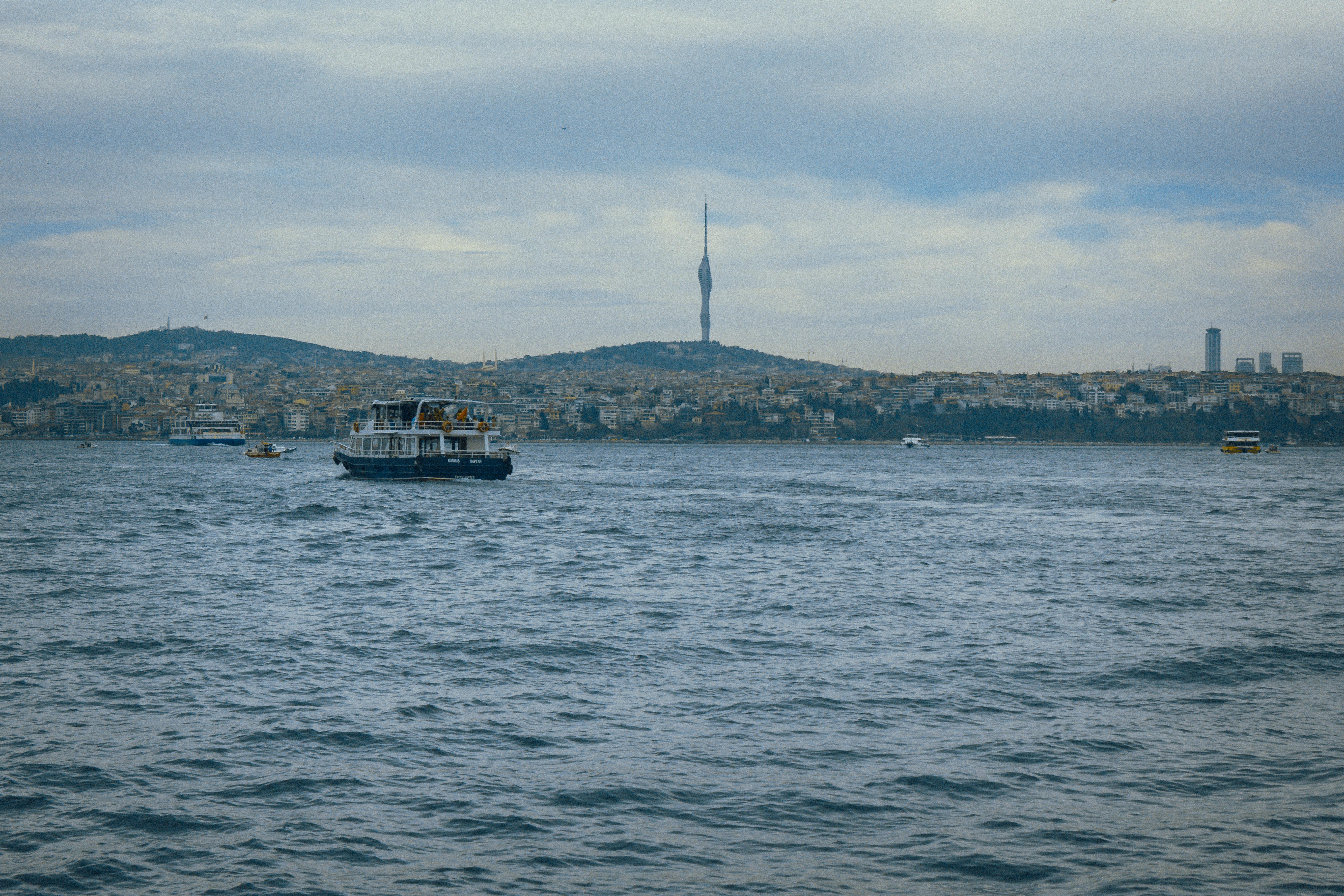 A White and Blue Ferry Boat Sailing on the Sea · Free Stock Photo