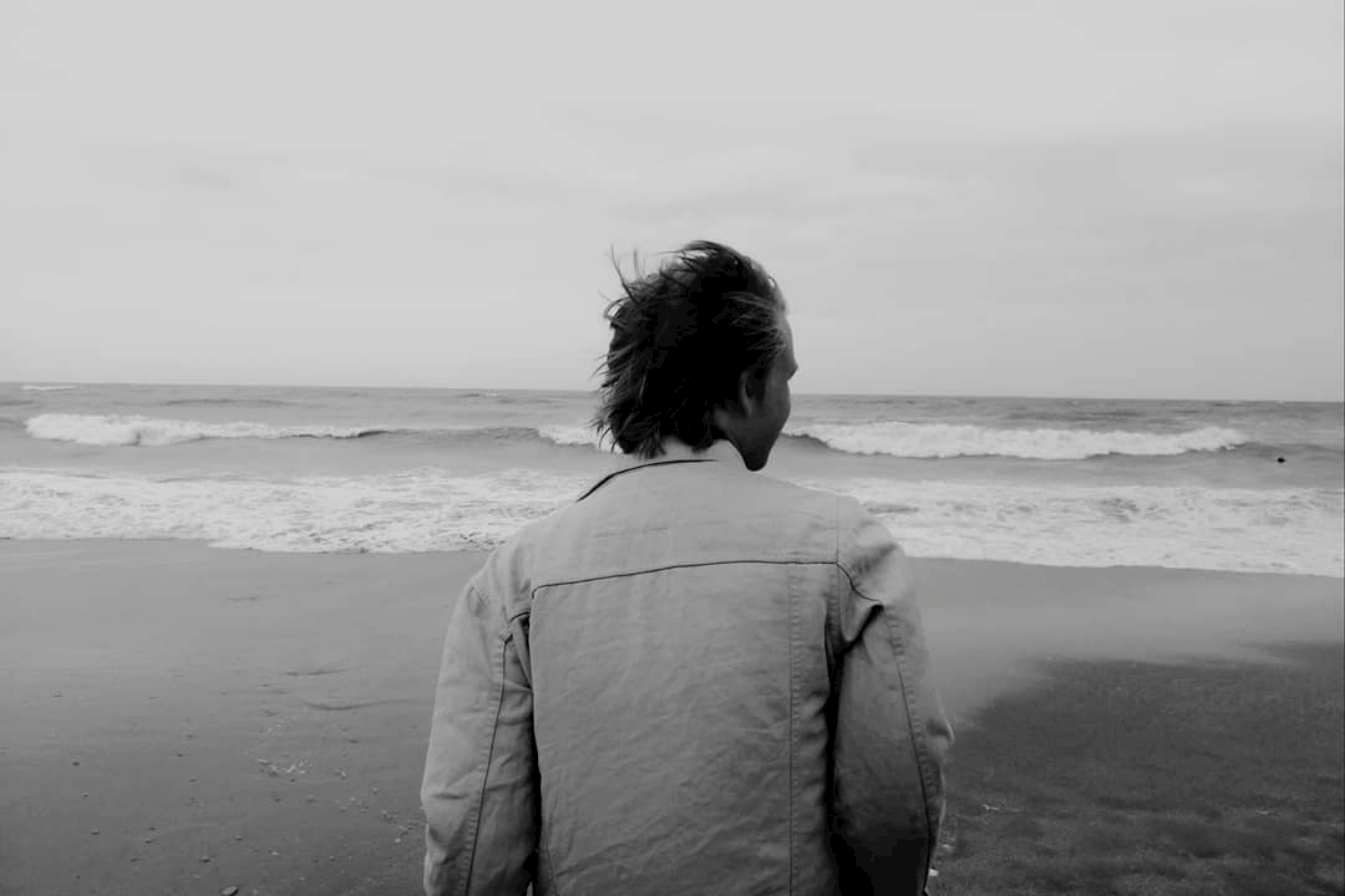 Man Standing on the Beach Looking at the Waves · Free Stock Photo