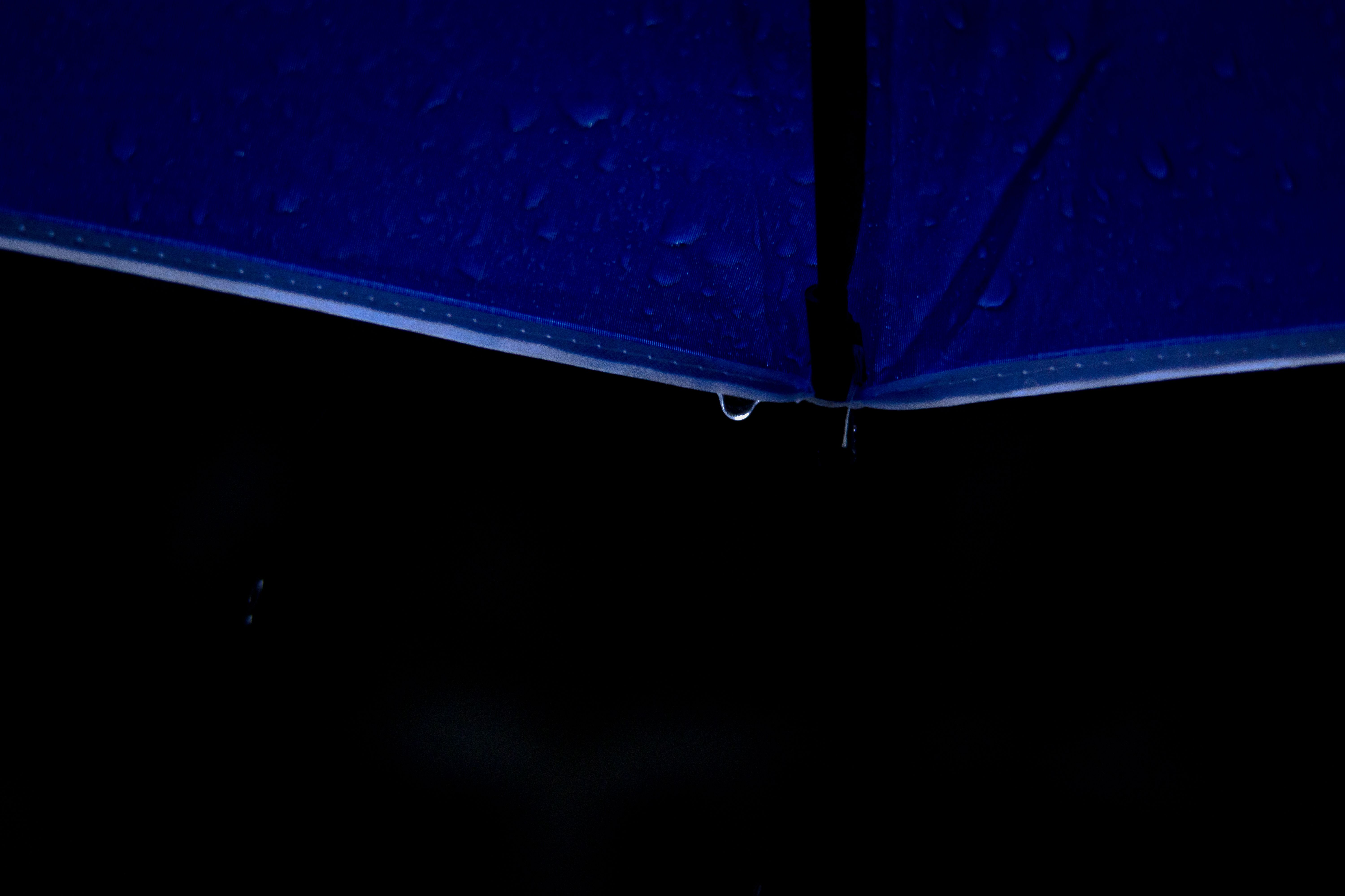 A Water Droplet Hanging on a Blue Umbrella · Free Stock Photo