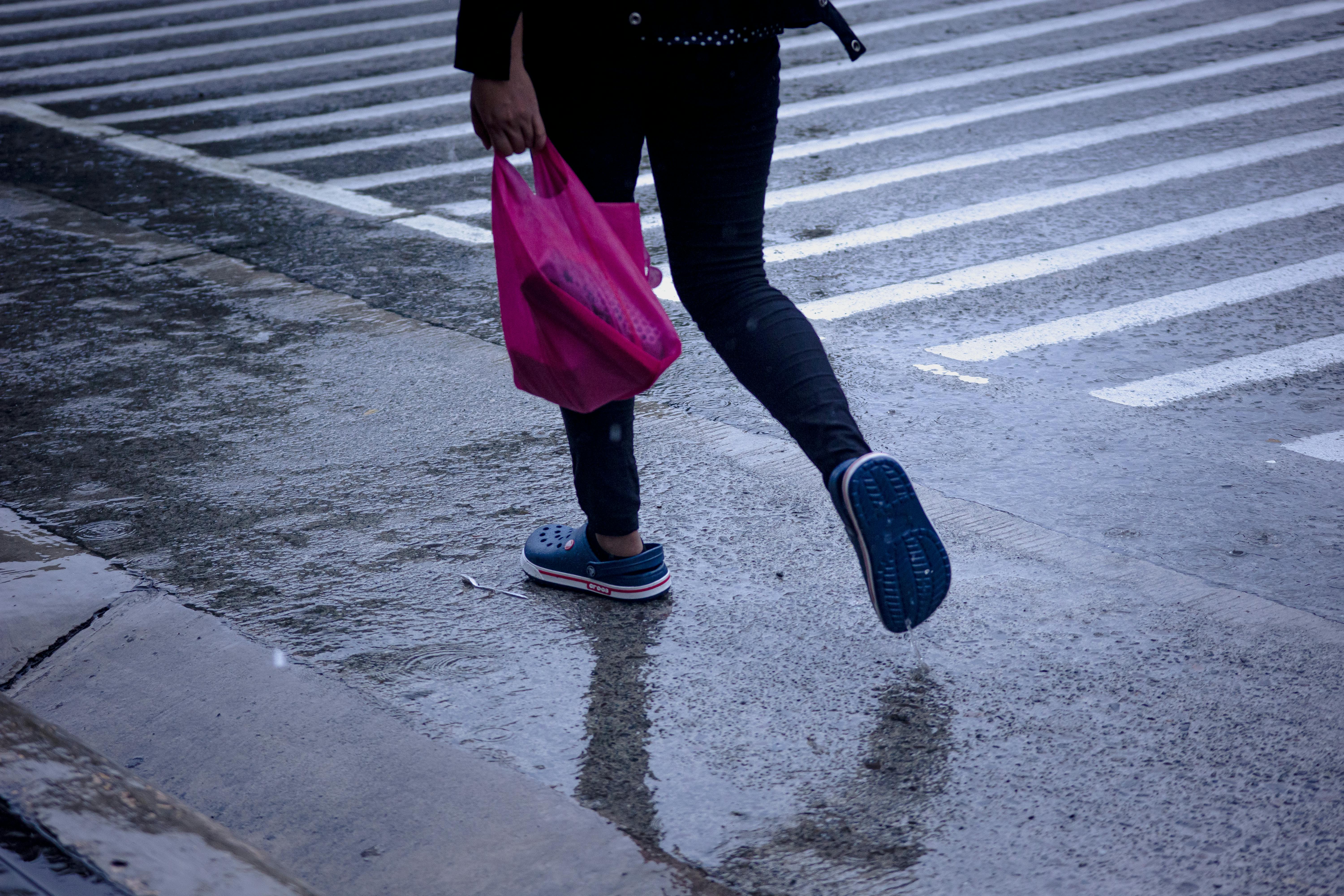 A Person Walking while Carrying a Shopping Bag · Free Stock Photo