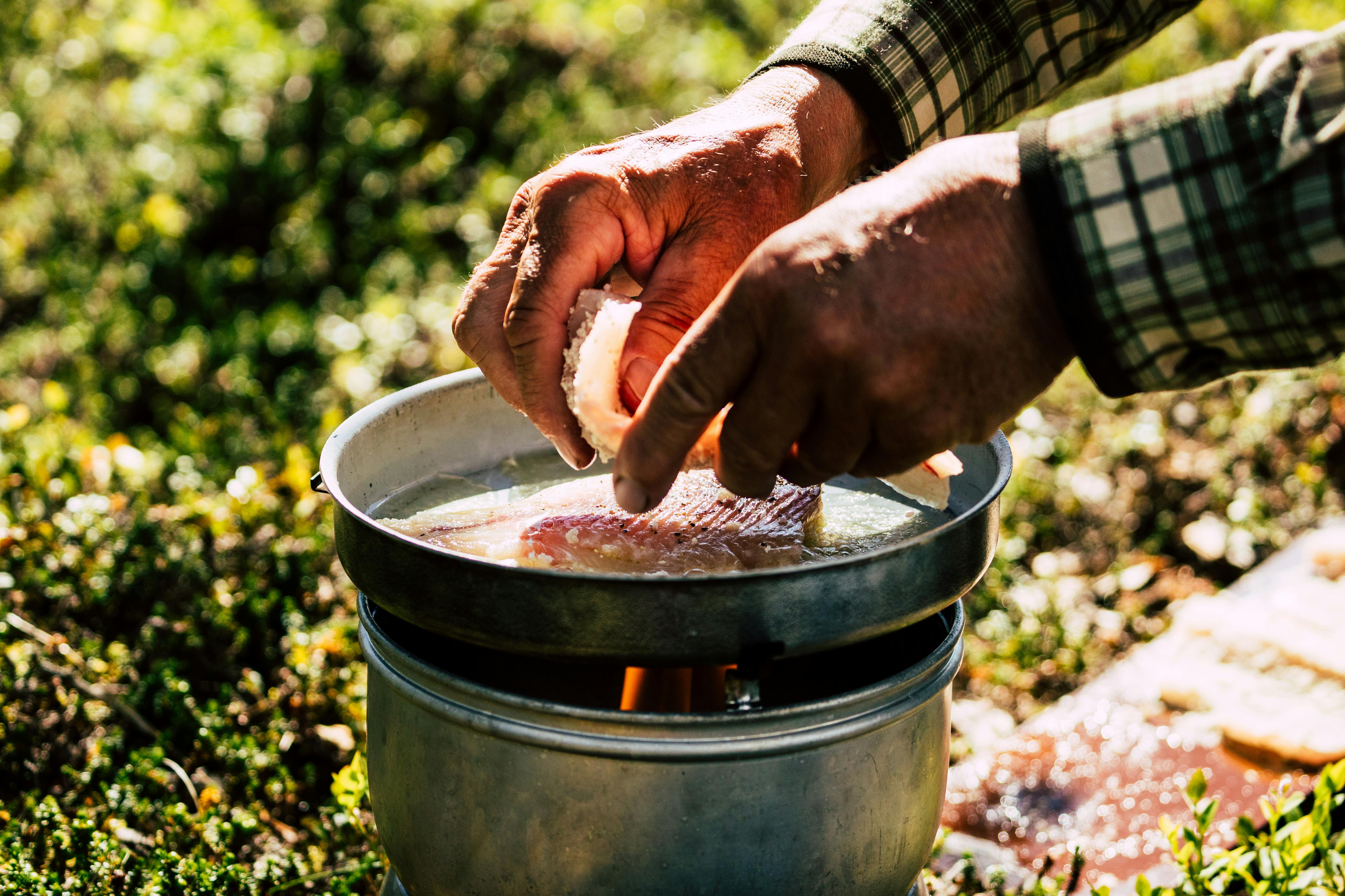 A Person Frying Fish in the Outdoors · Free Stock Photo