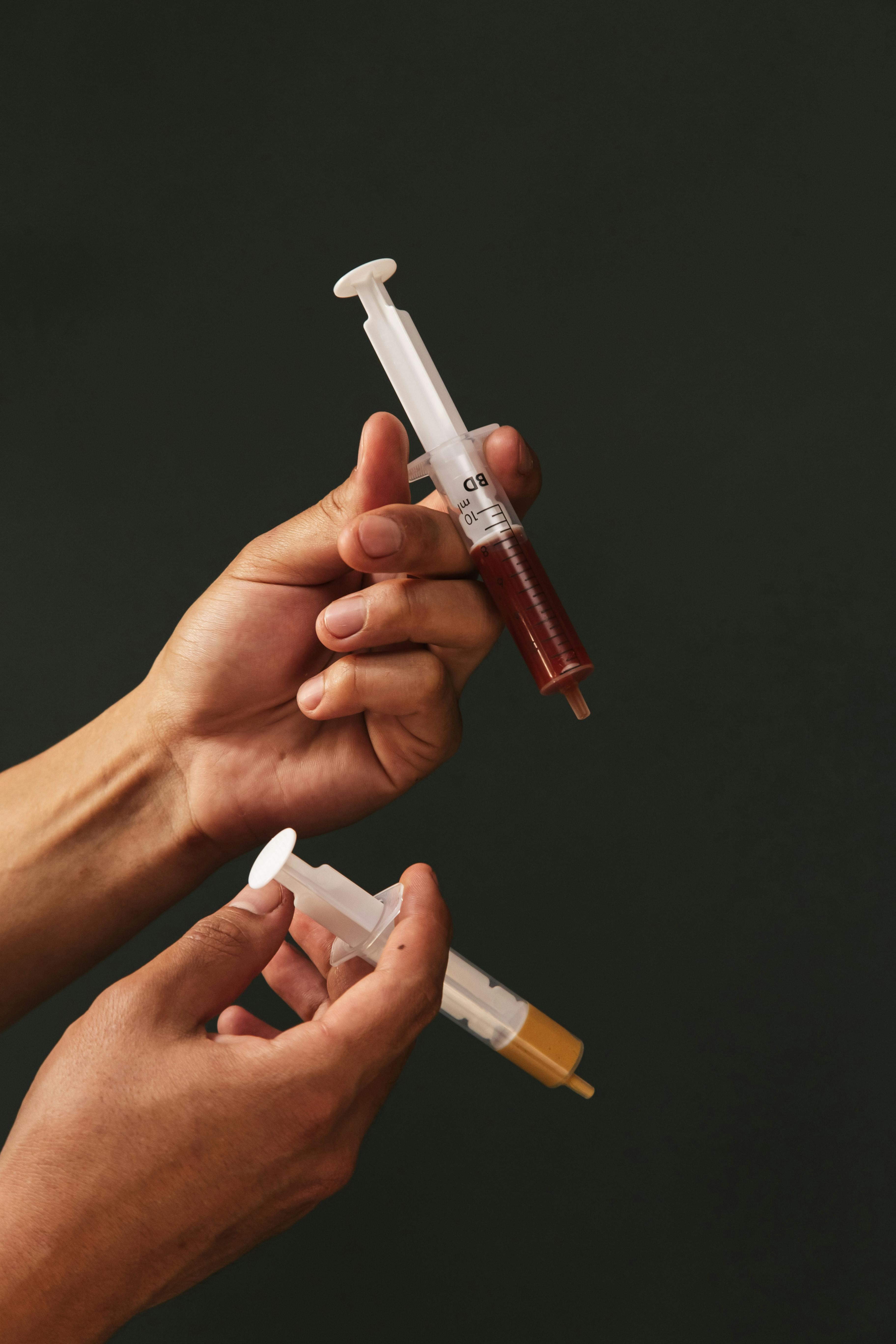 A Person Holding Syringes · Free Stock Photo