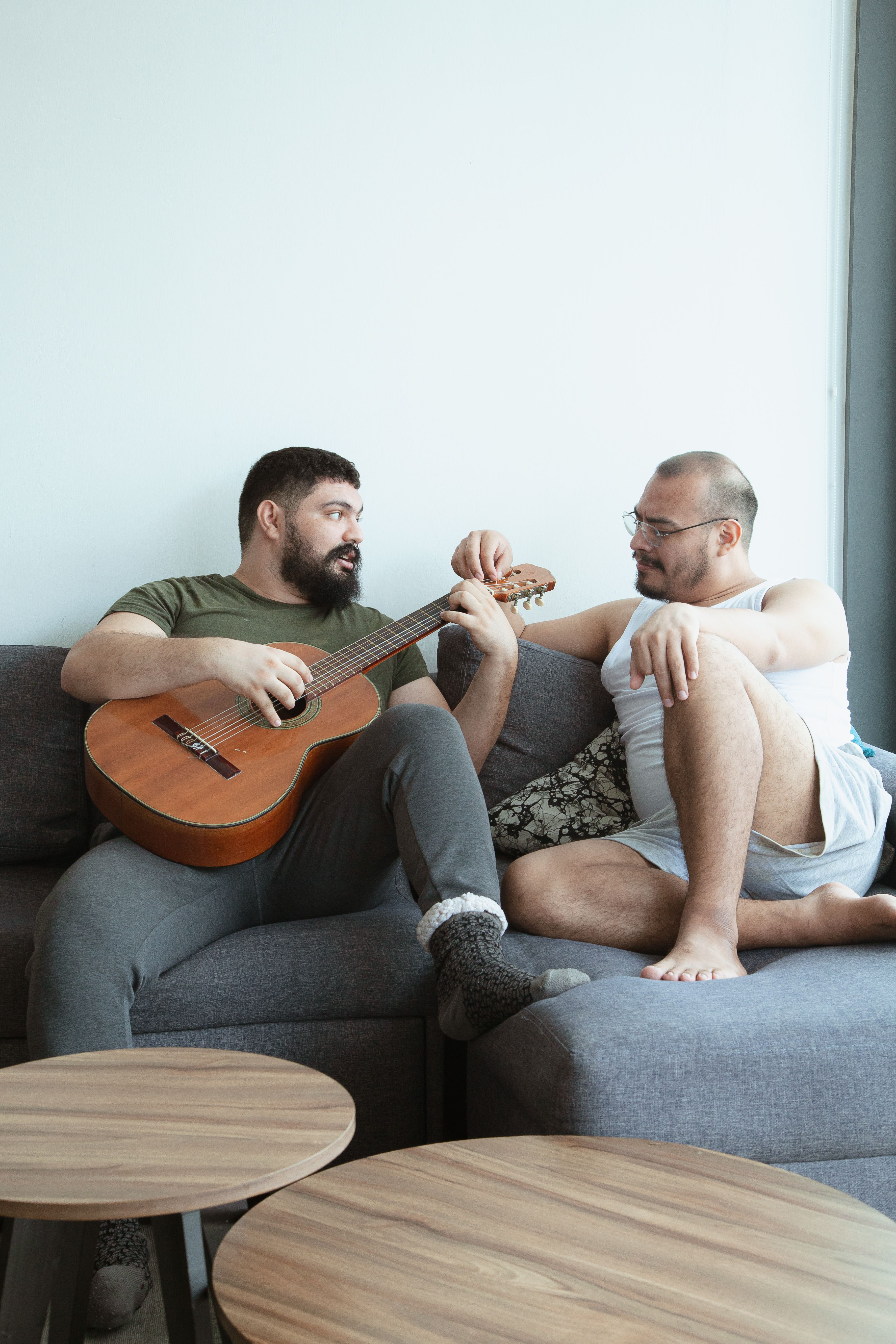 Two Men Sitting on a Couch Looking at Each Other With a Smile · Free ...