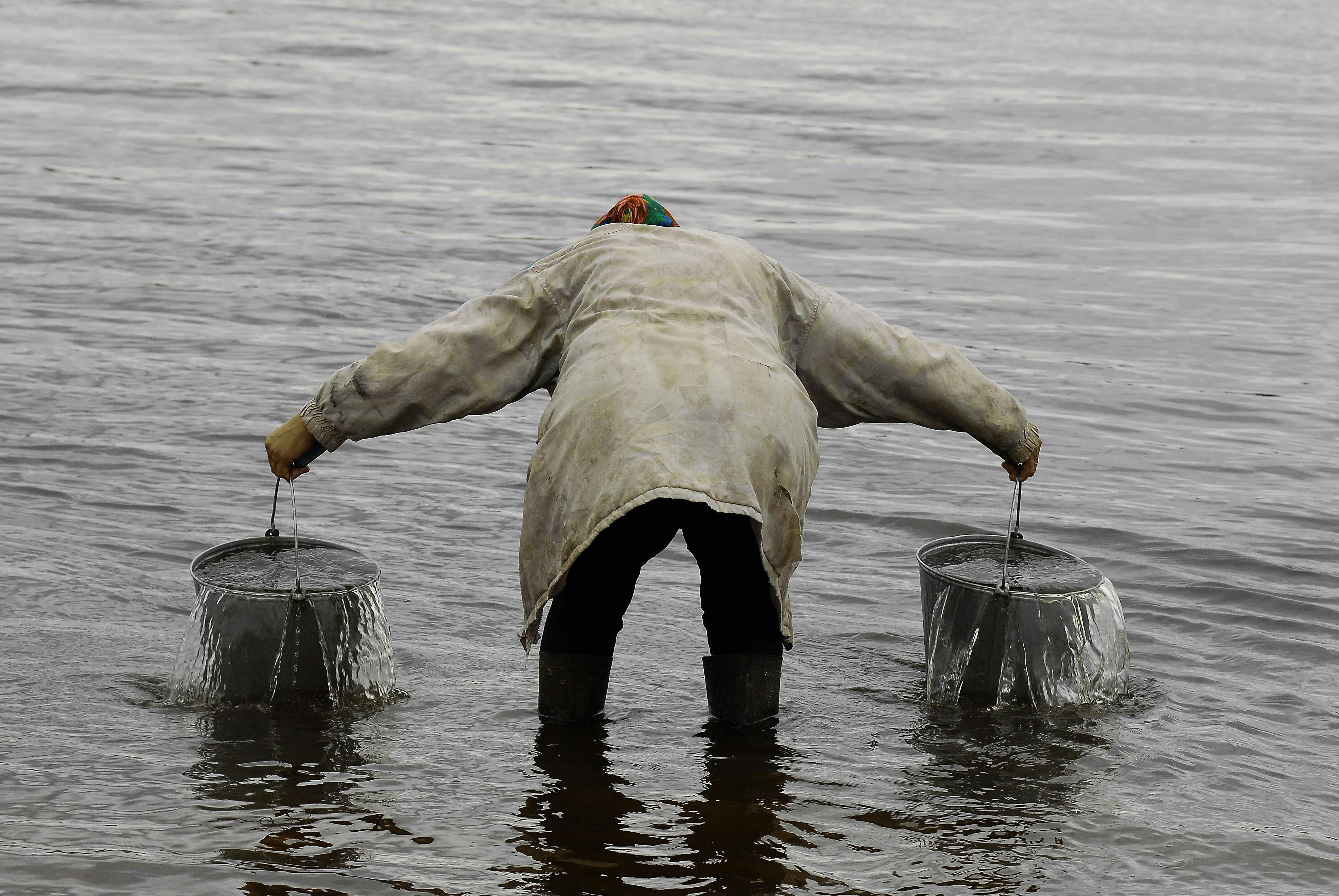 Person Carrying Container on the Head on Road · Free Stock Photo