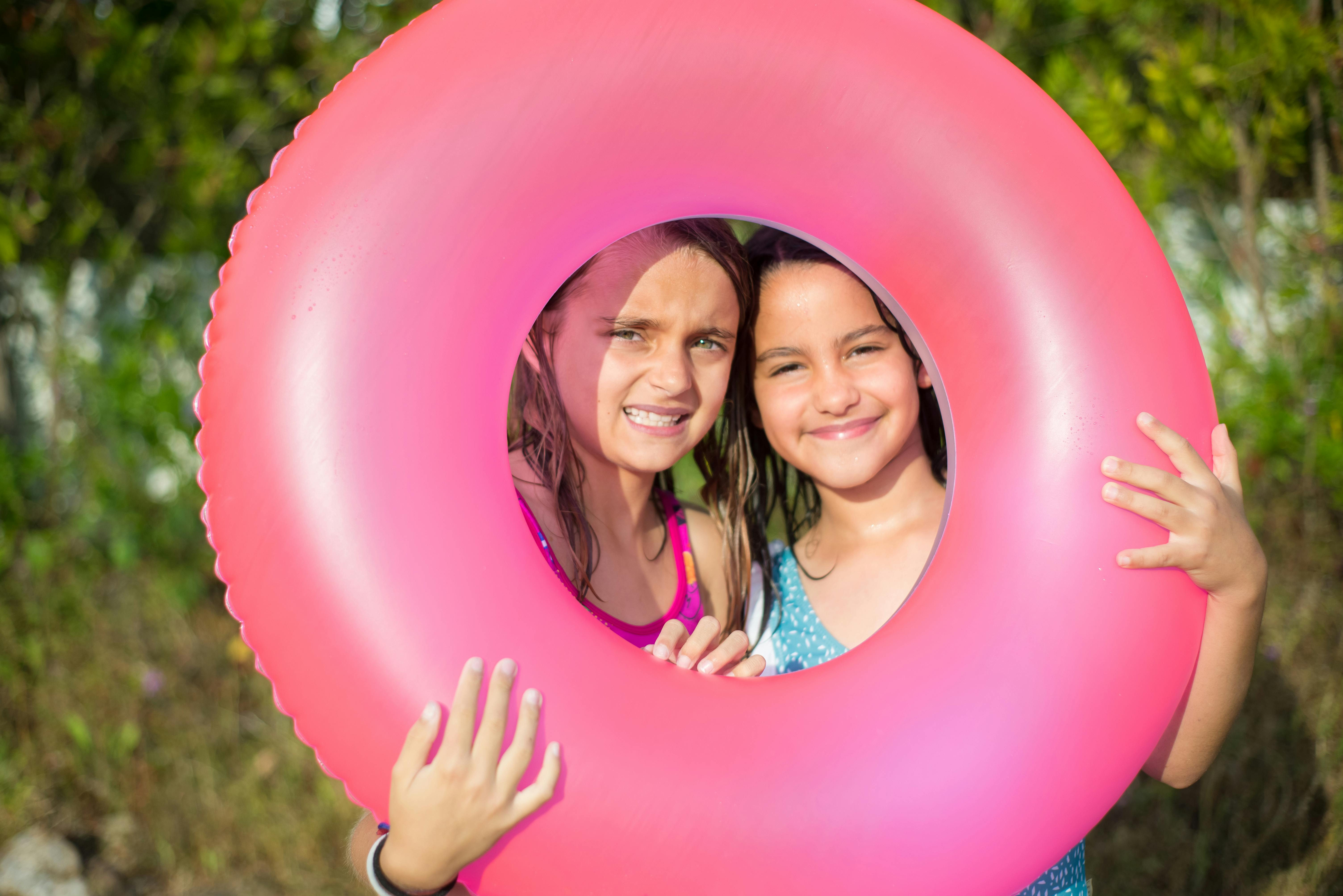 Girls Holding Pink Inflatable Ring · Free Stock Photo