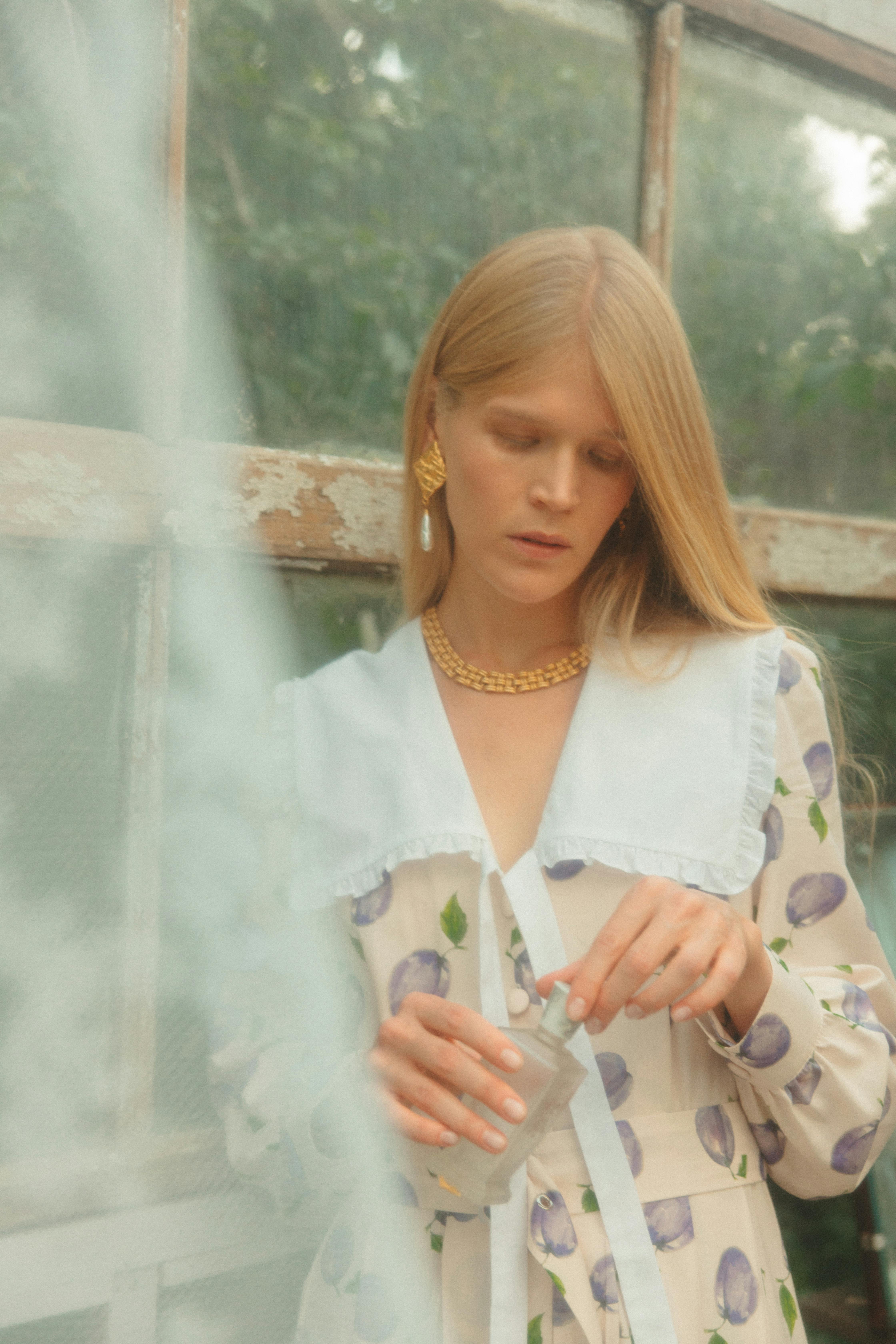 A Woman in Vintage Dress Holding a Glass Bottle · Free Stock Photo