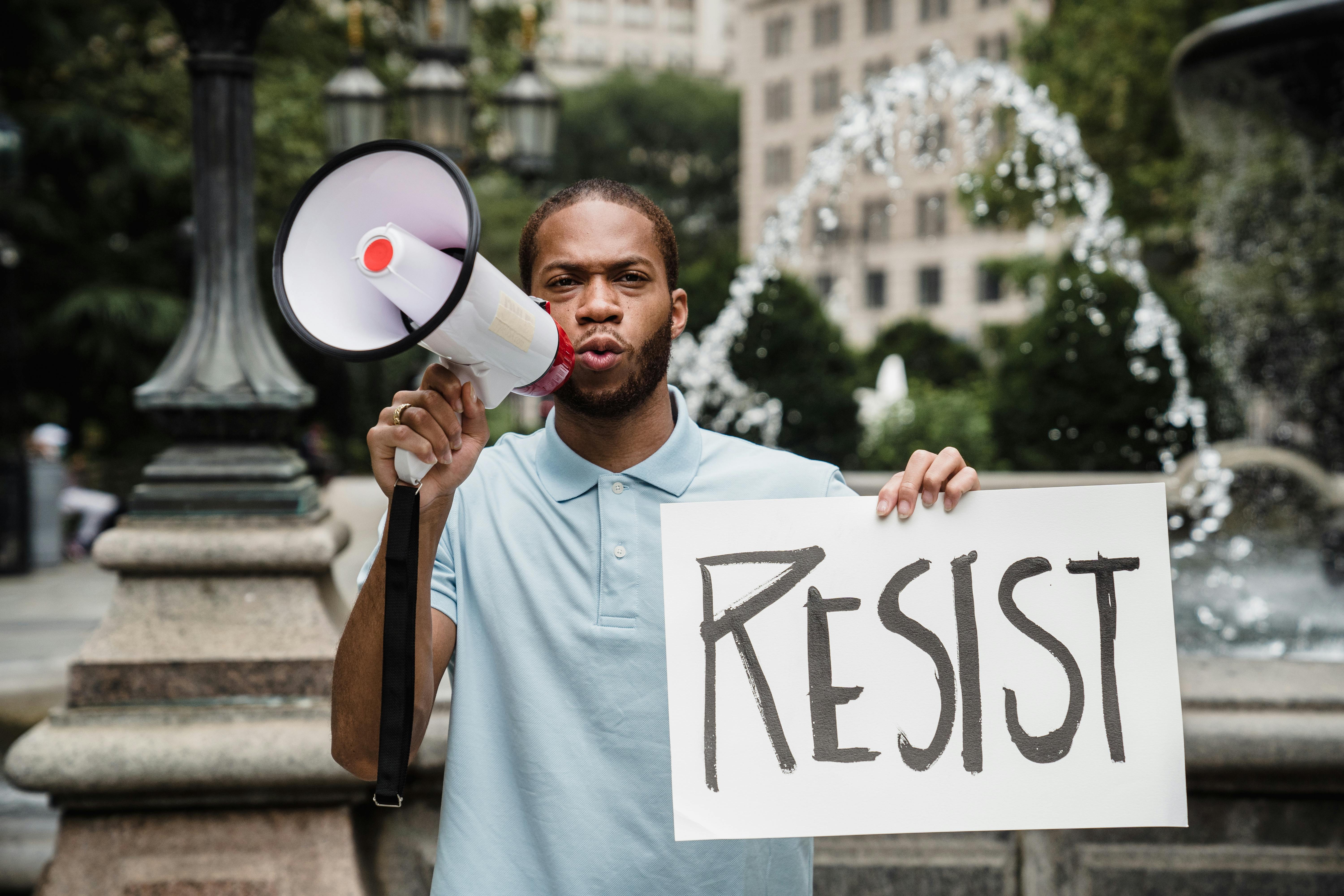 Man with Megaphone and Poster on Street Demonstration · Free Stock Photo