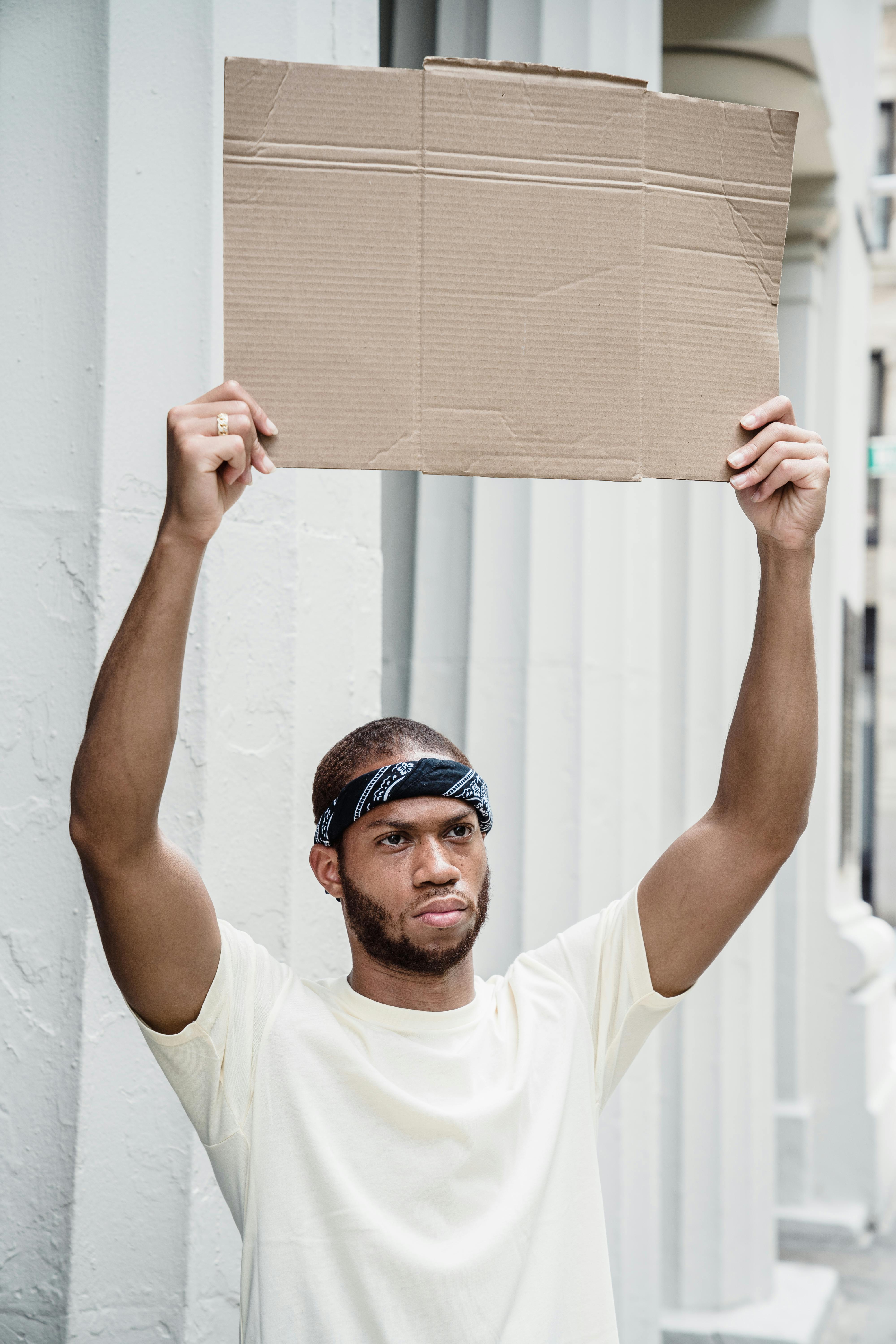 Young Man Holding Cardboard Blank Banner · Free Stock Photo