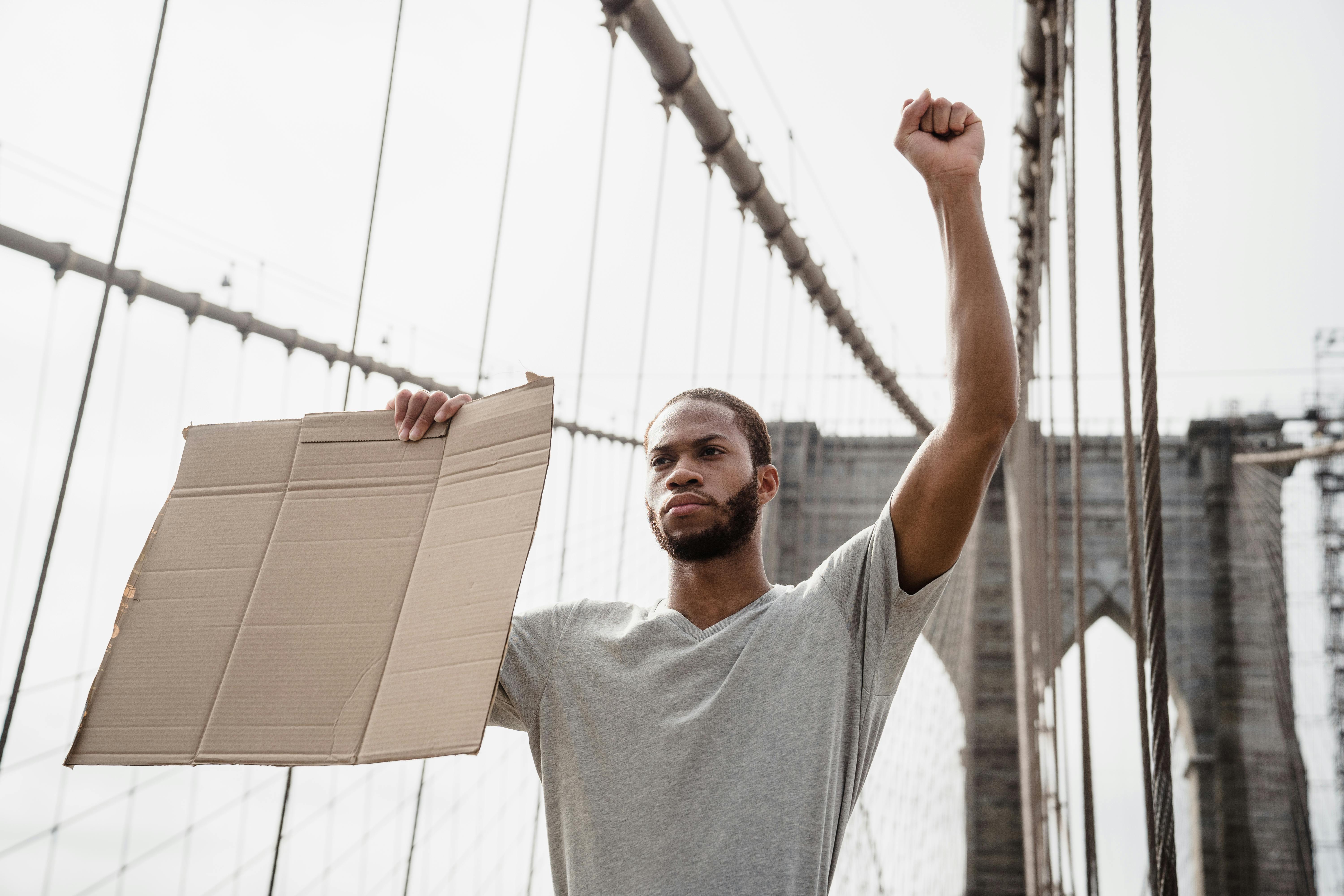 A Man Segregating Trash while Holding a Cardboard · Free Stock Photo
