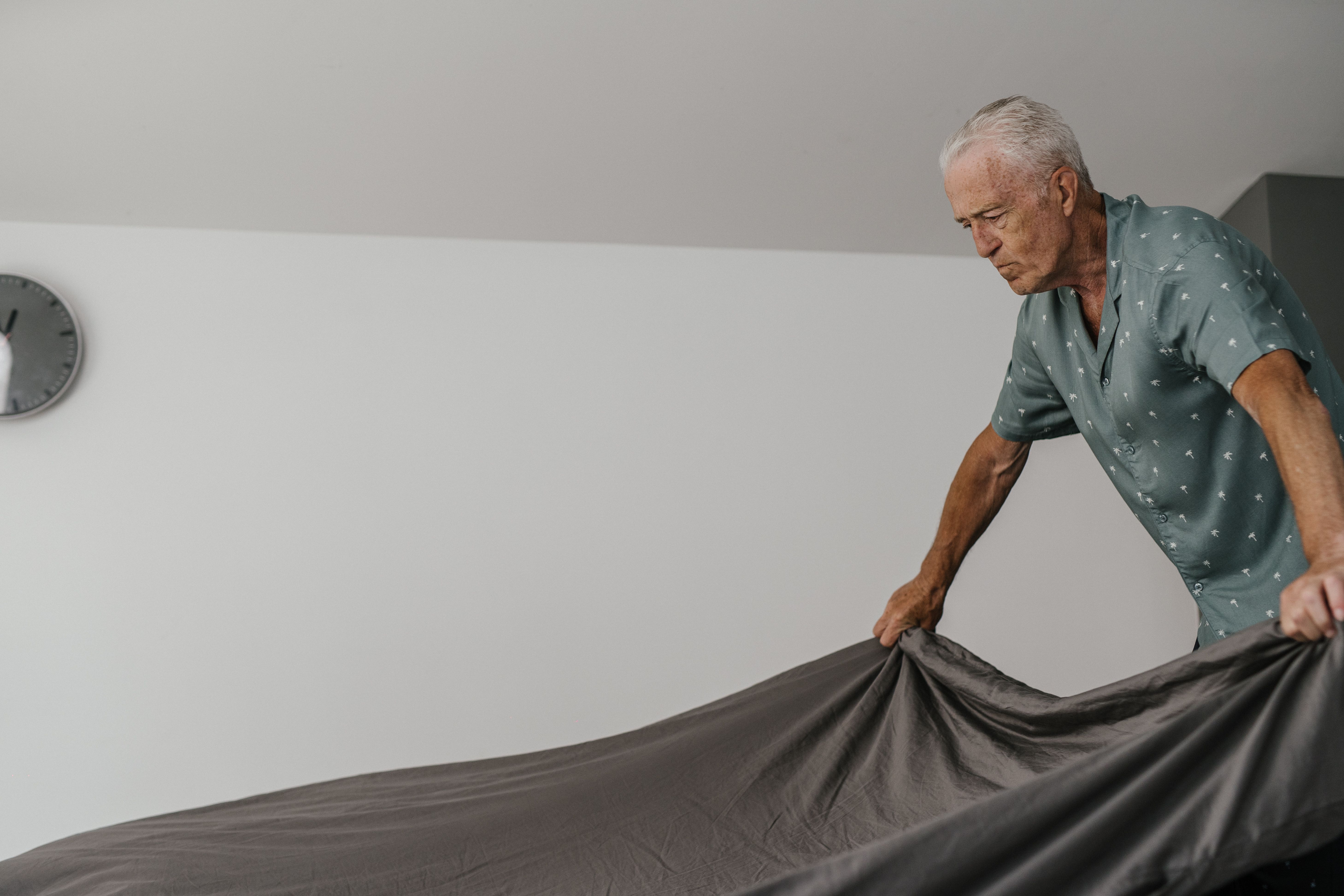 An Elderly Man Fixing a Bed · Free Stock Photo