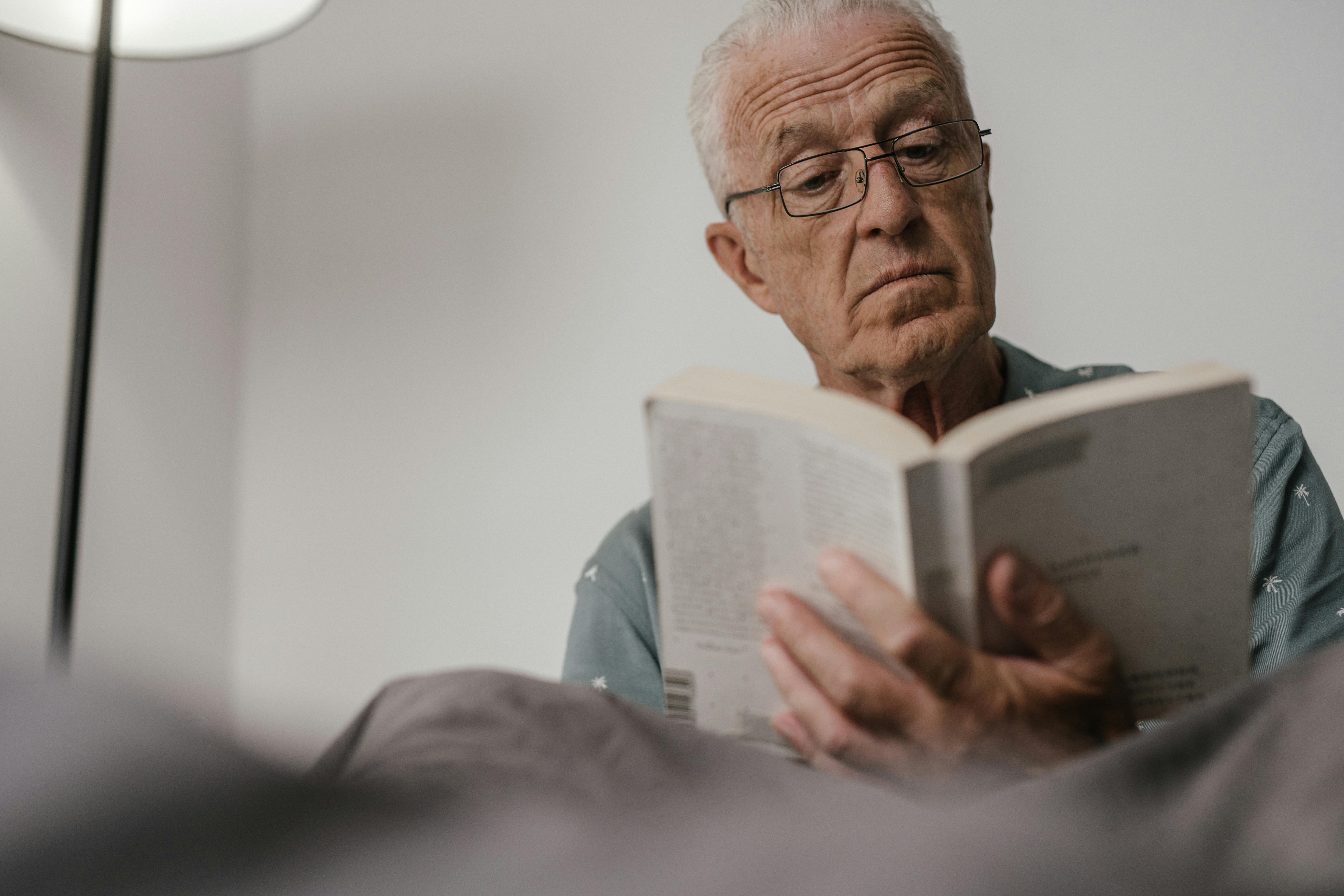 Close-Up Shot of an Elderly Man with Eyeglasses Reading a Book · Free ...