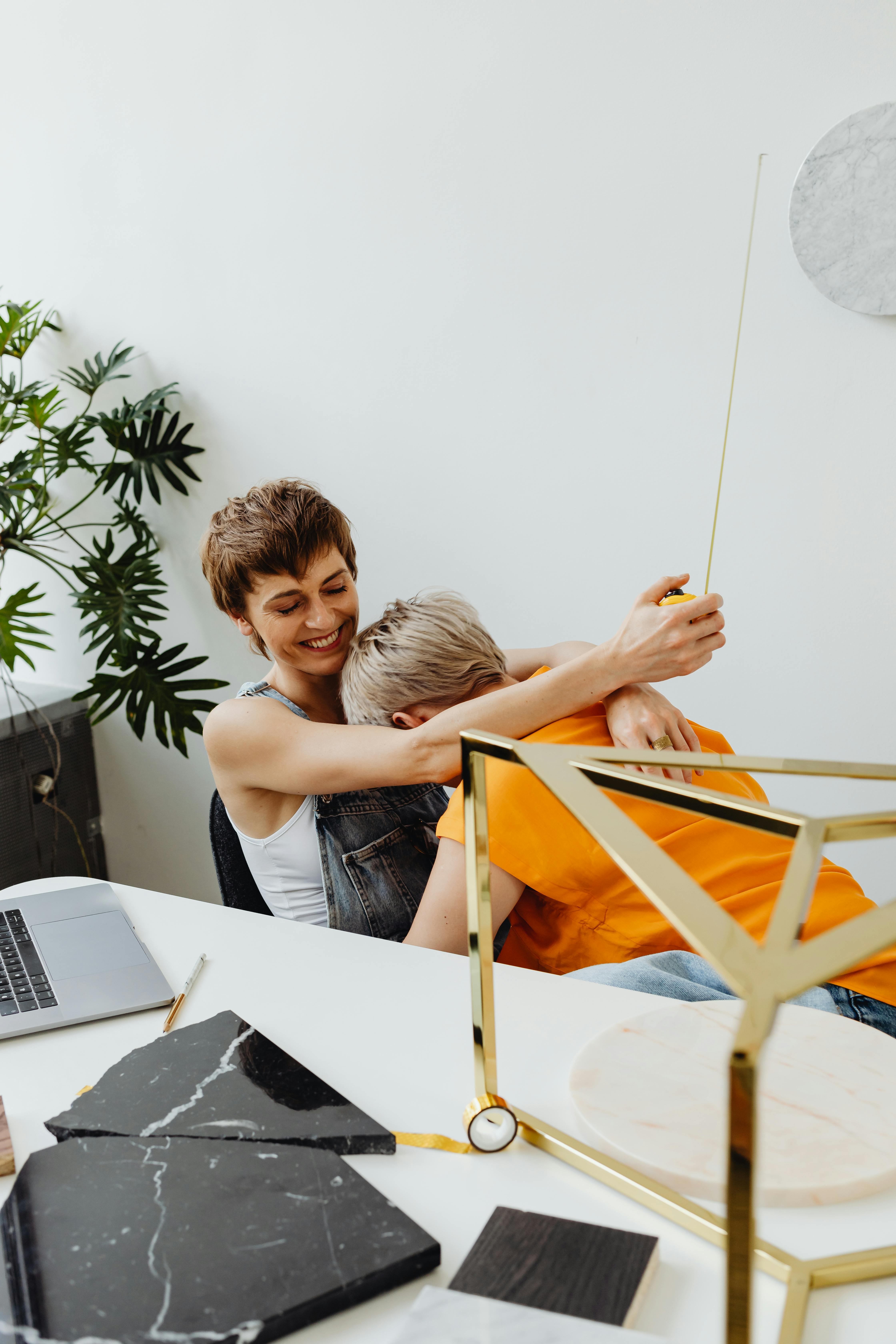 Woman in White Tank Top Hugging Woman in Orange Shirt · Free Stock Photo